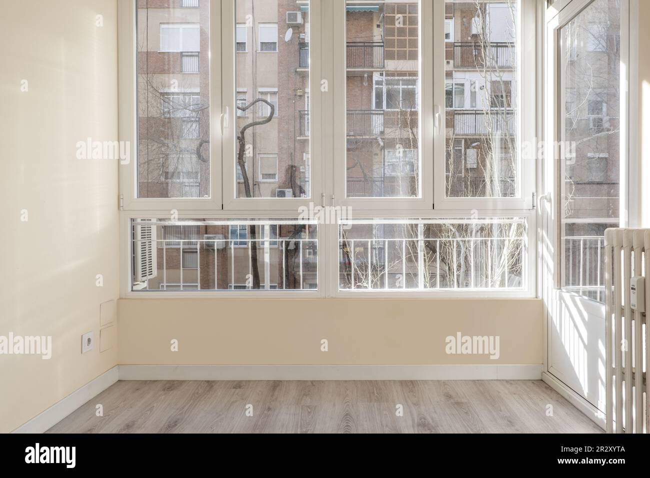 A viewing terrace with a white aluminum enclosure in an empty flat with ...
