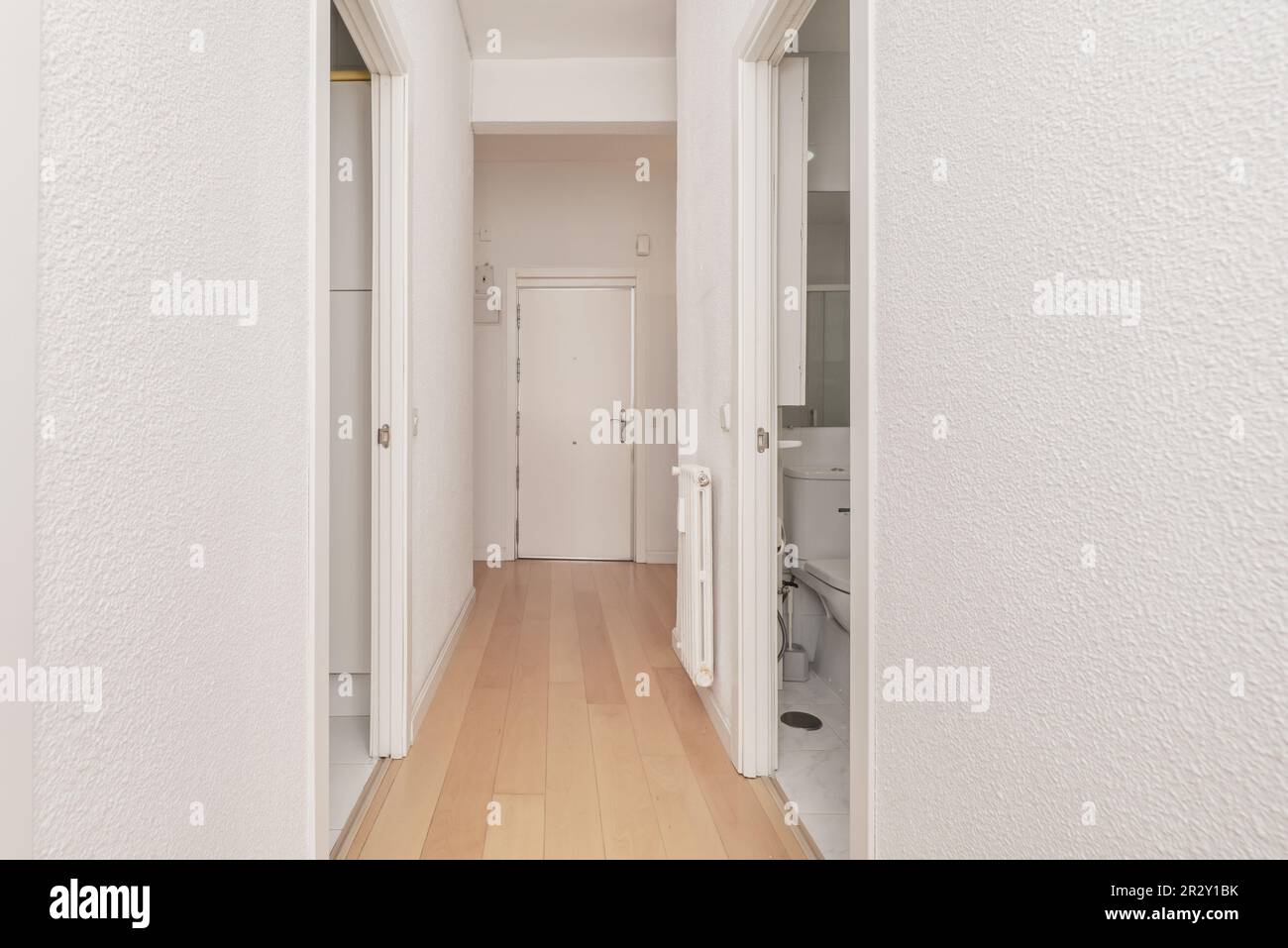 A corridor of a house with access doors to several rooms and a bathroom ...