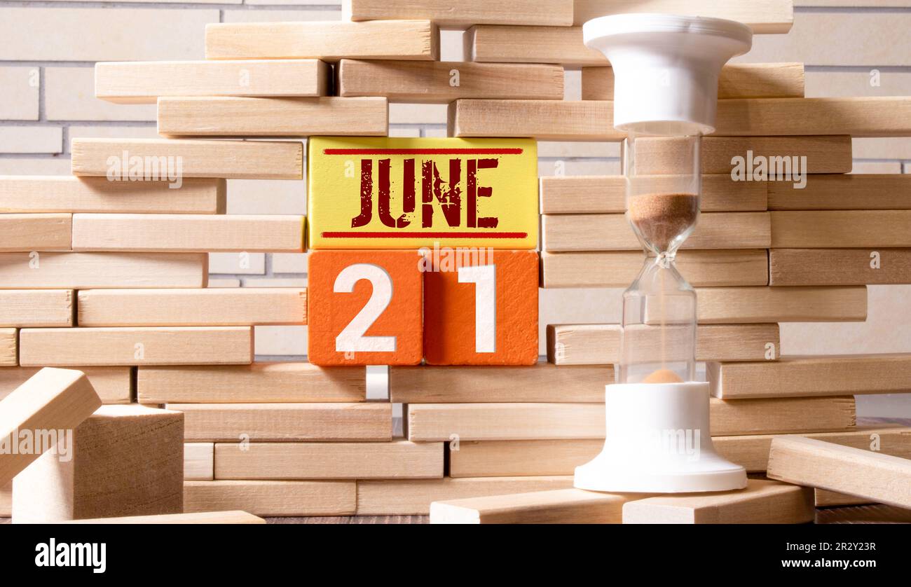 June 21 calendar date text on wooden blocks with blurred nature ...