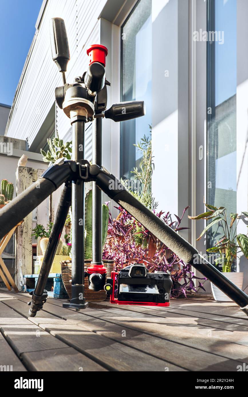 A photo camera placed on a tripod with an articulated arm to place it ...