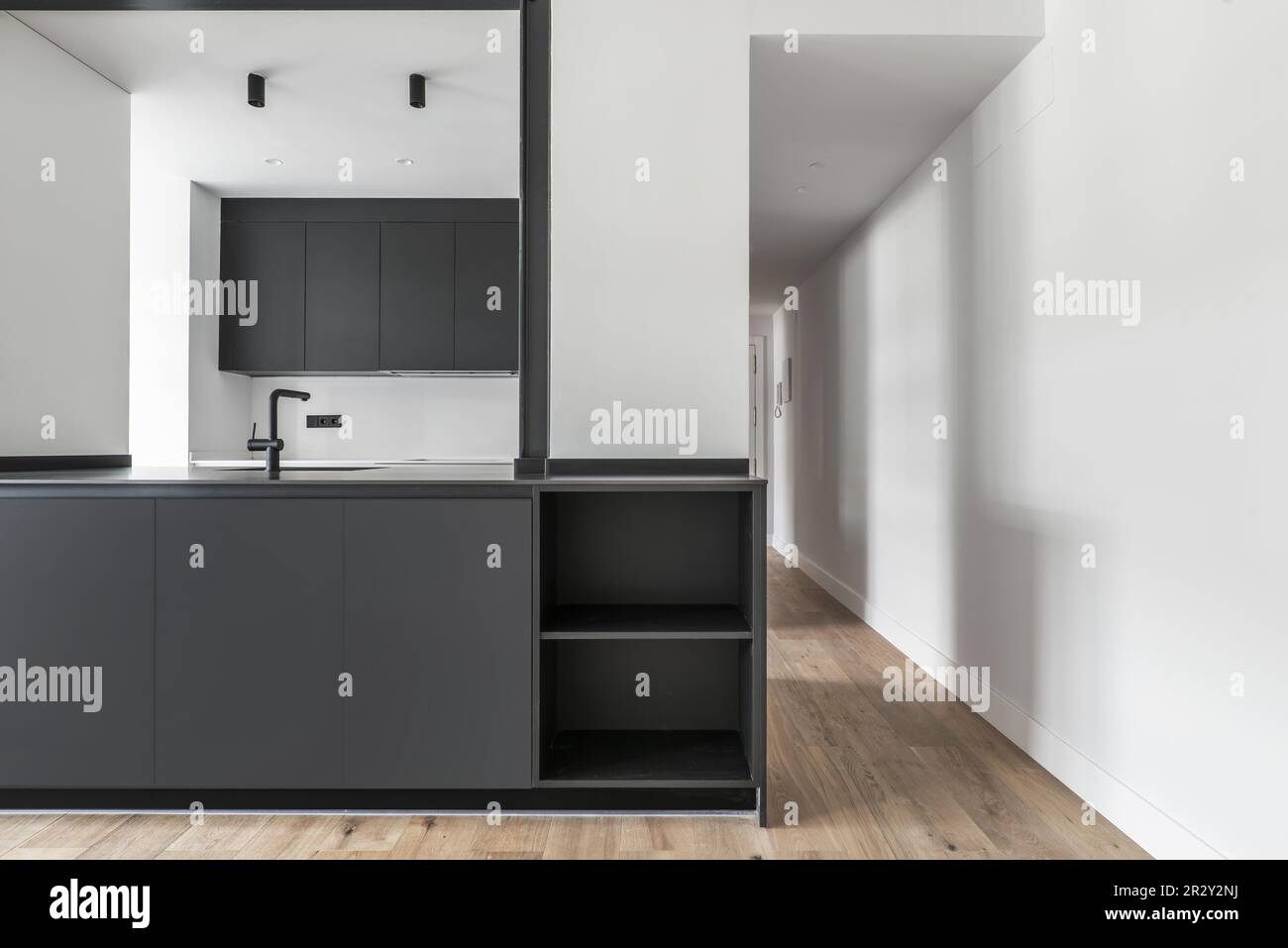 White walled living room with kitchen equipped with serving hatch and ...