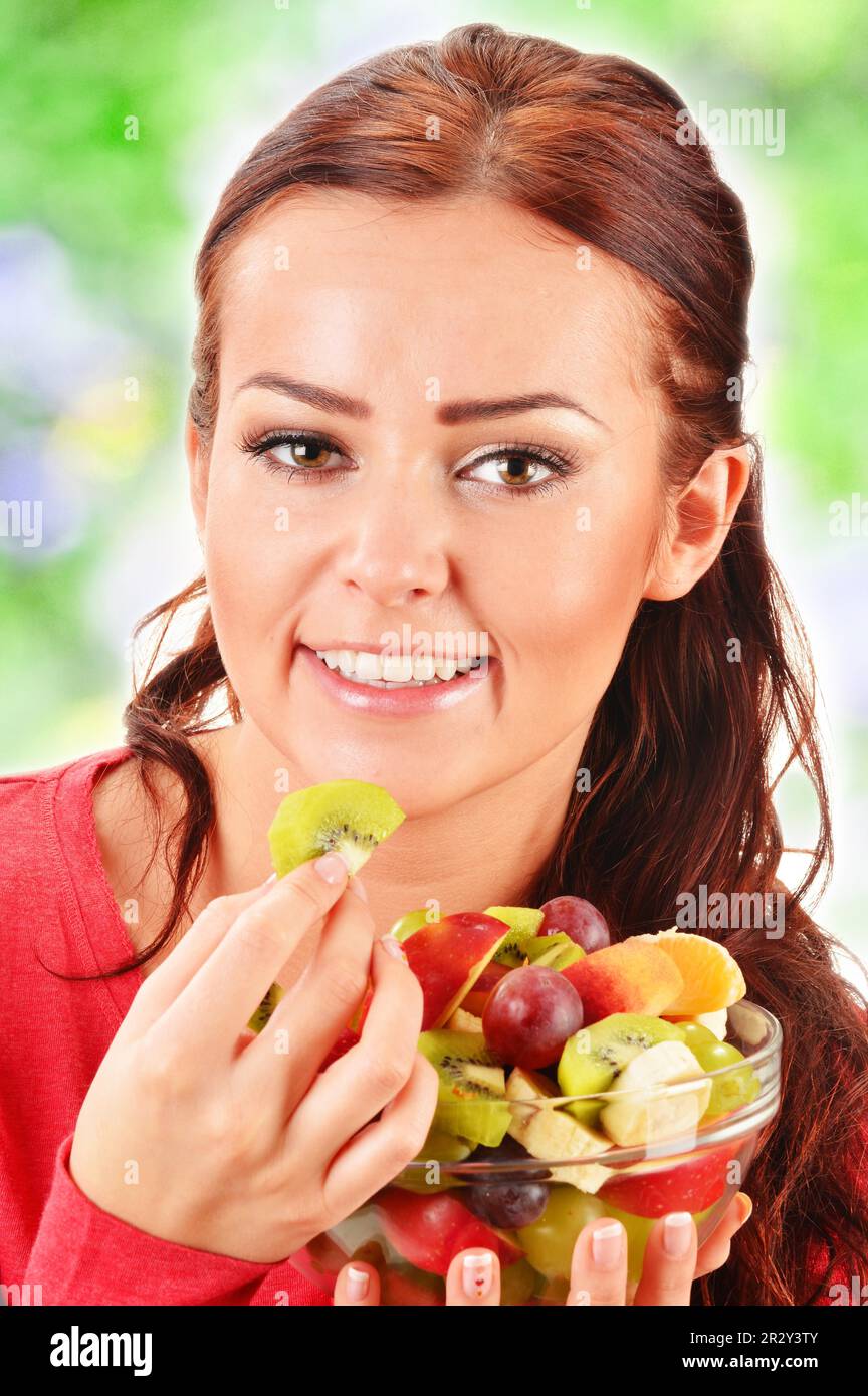 Young woman eating fruit salad Stock Photo - Alamy