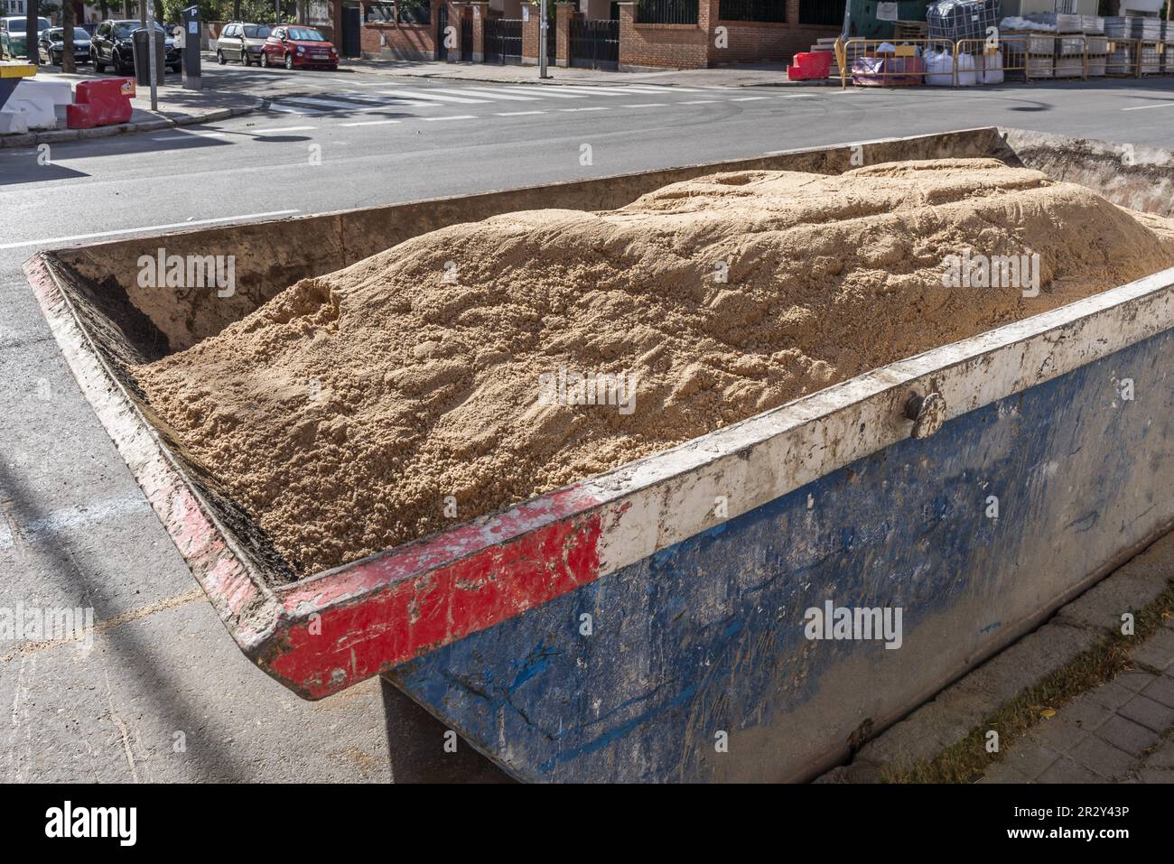 A construction container parked in the street full of sand to work ...