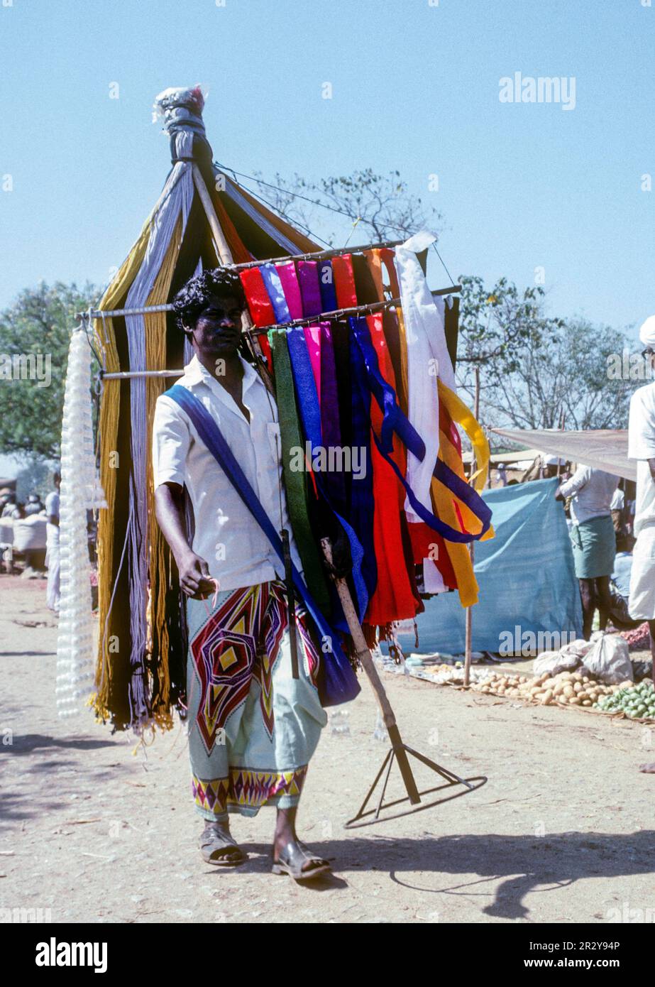 A man selling colorful ribbons, weekly Periodical market at Pollachi ...