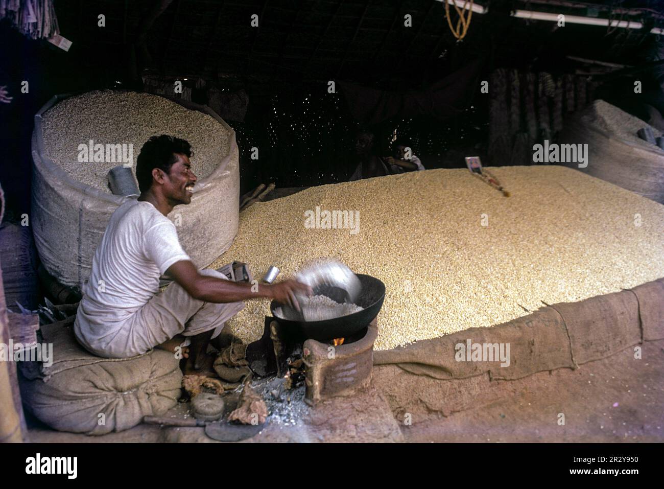A man roasting puffed rice, weekly Periodical market at Thudiyalur ...