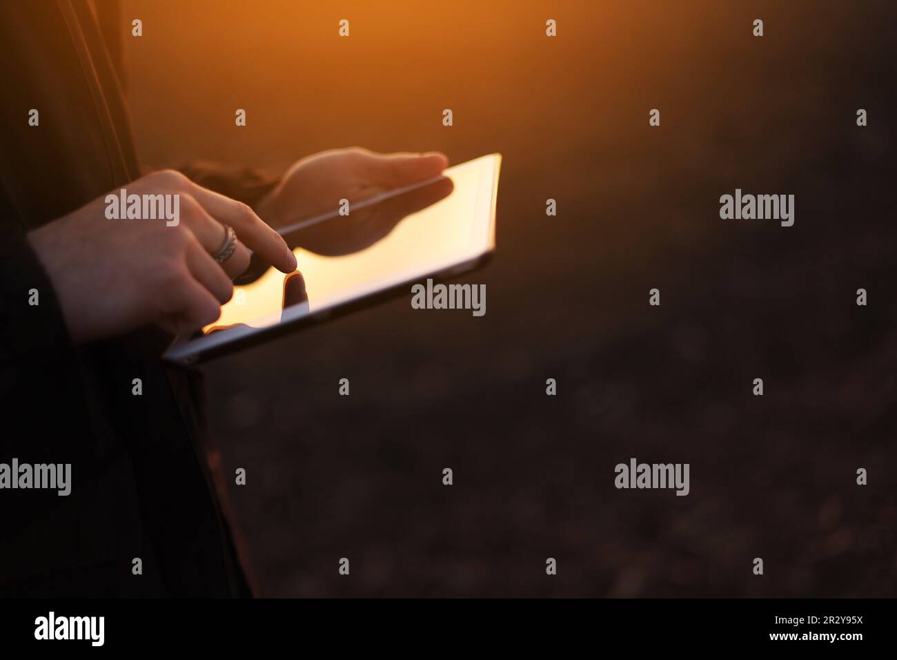 Cropped shot of male farmer's hands use digital tablet on plowed field ...