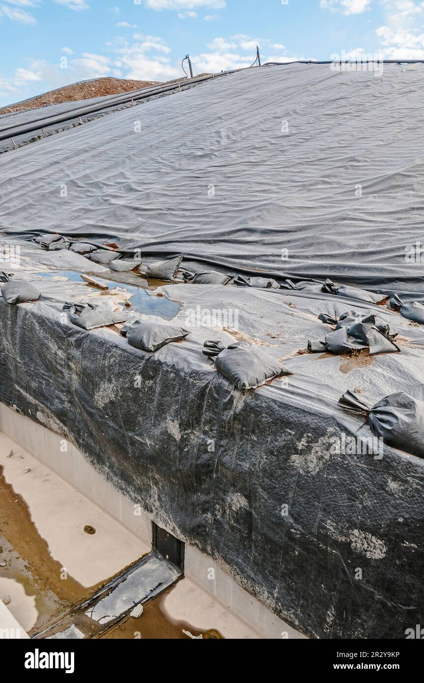 Close image of sandbags holding down geomembrane near a concrete ...