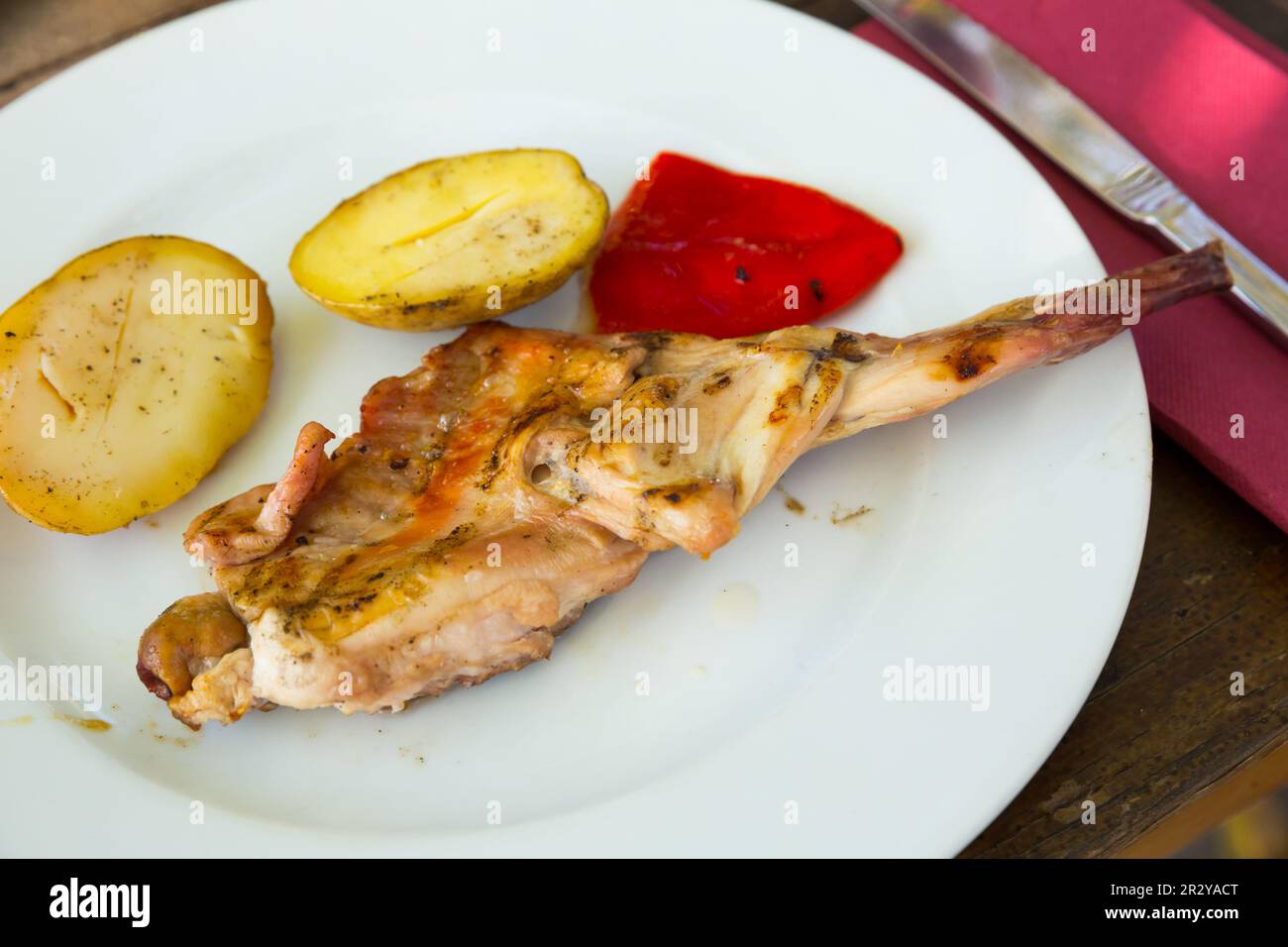 Grilled rabbit thigh with bell pepper and potatoes Stock Photo - Alamy