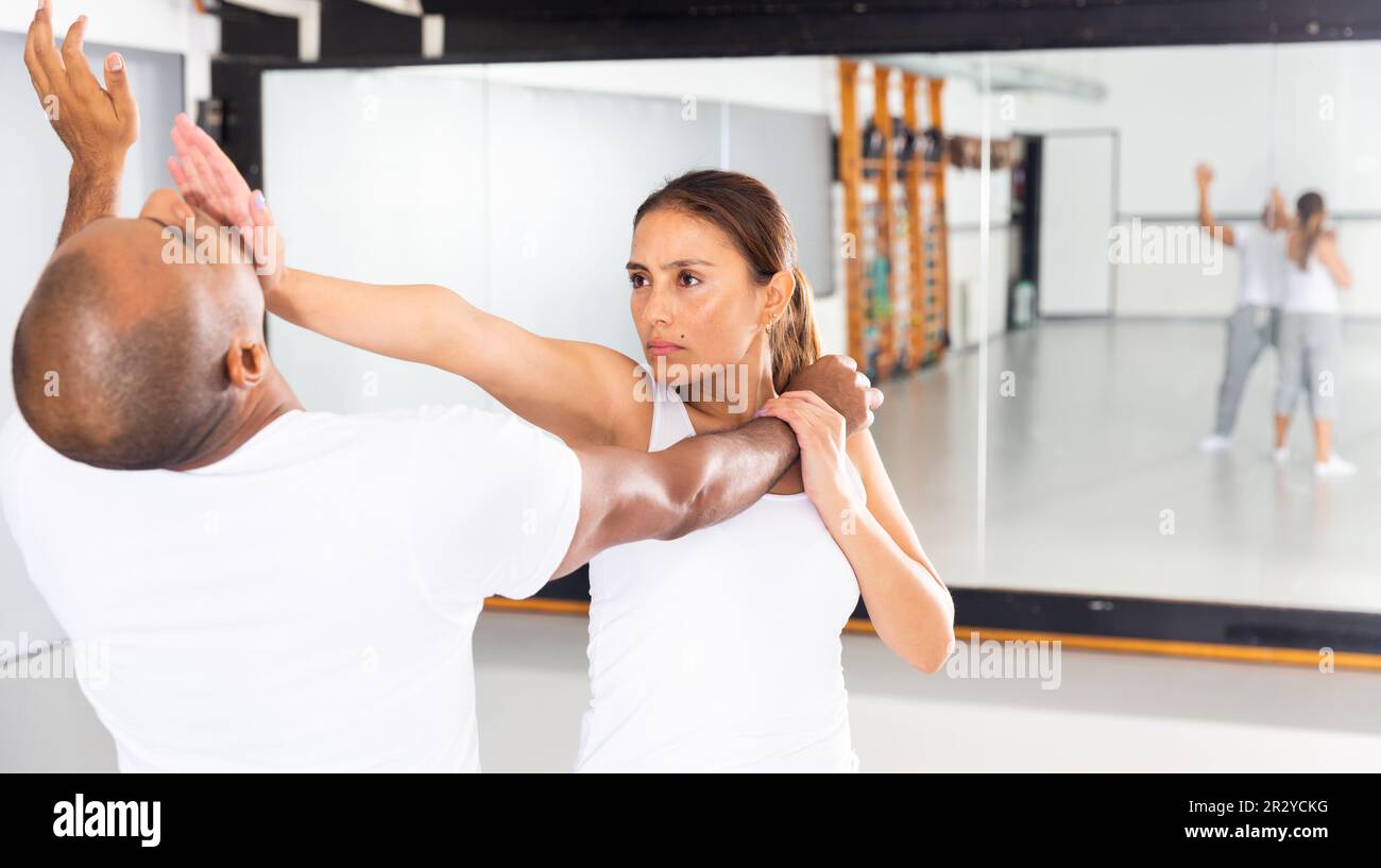 Woman and man at self protection workout, training attack movements ...