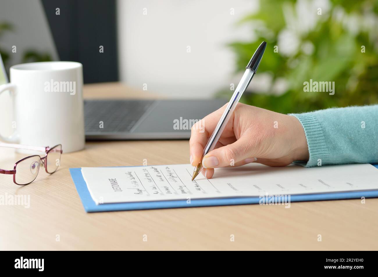 Close up of a woman hand filling form on a table Stock Photo - Alamy