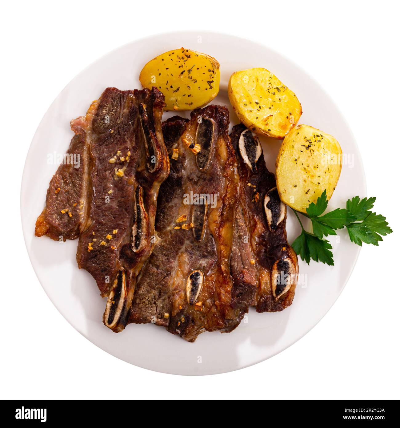 Spanish cuisine churrasco de ternera, spare ribs with potatoes on ...