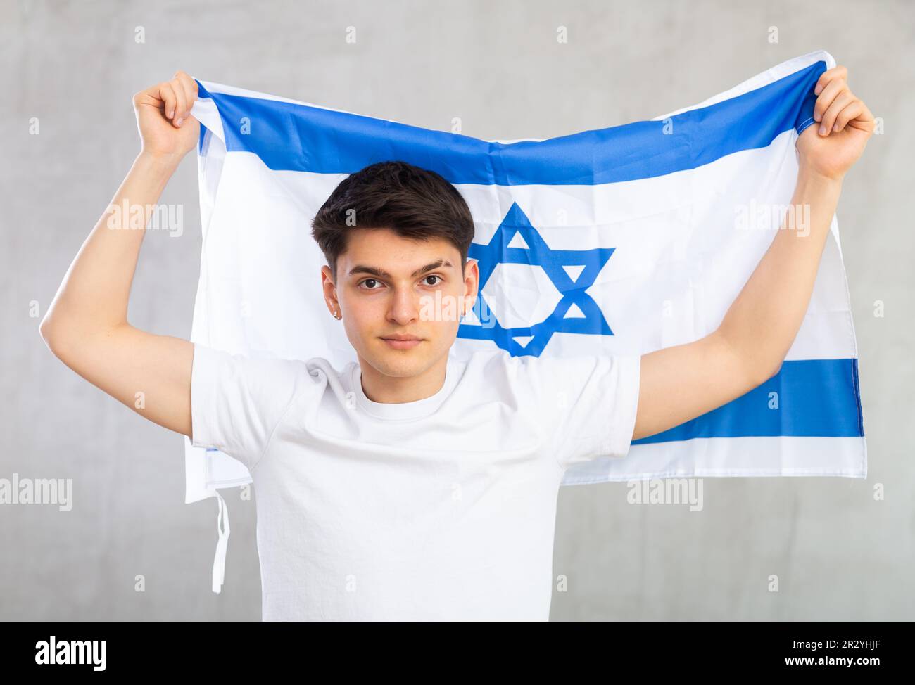 Guy holding the Israel flag in her hands Stock Photo - Alamy