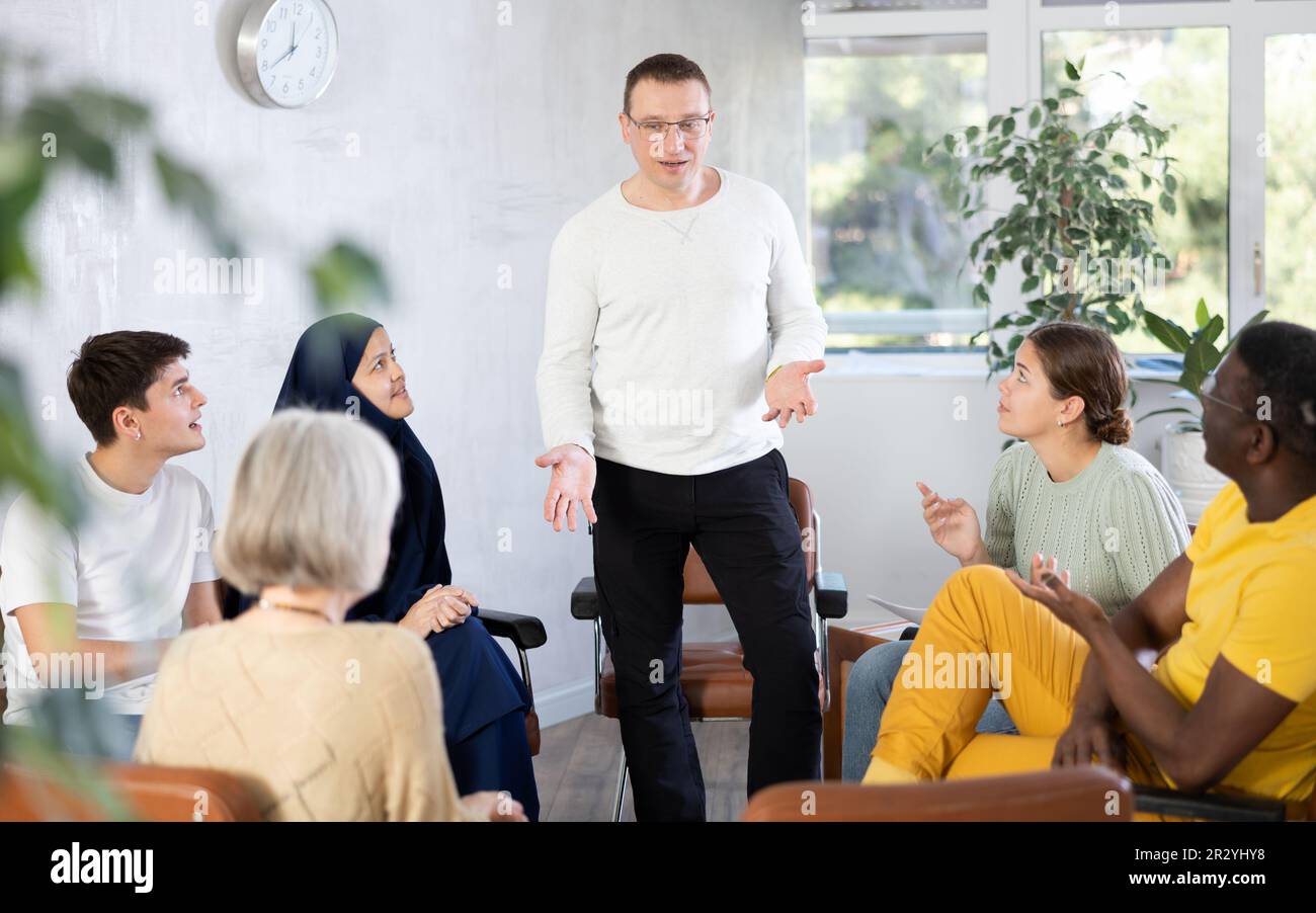 Male teacher lecturing at university with multinational students Stock ...