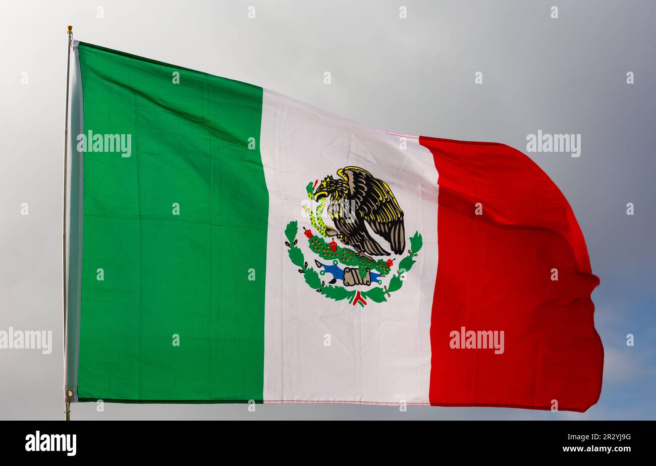 Mexican flag waving against blue sky Stock Photo - Alamy
