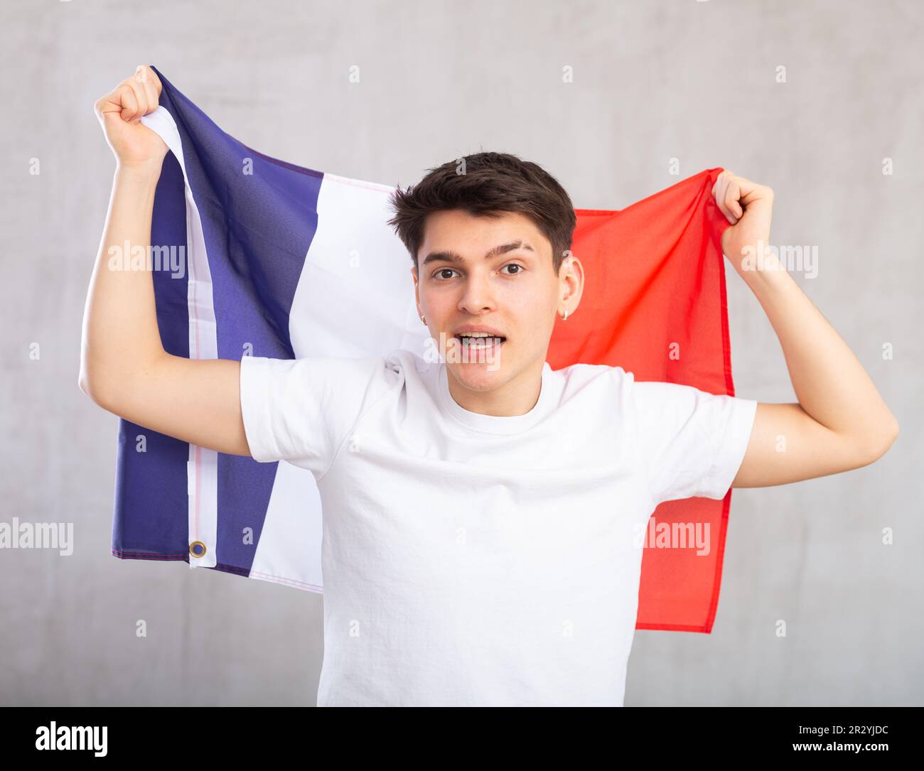 Energized,active male spectator holds national flag of France in hands ...