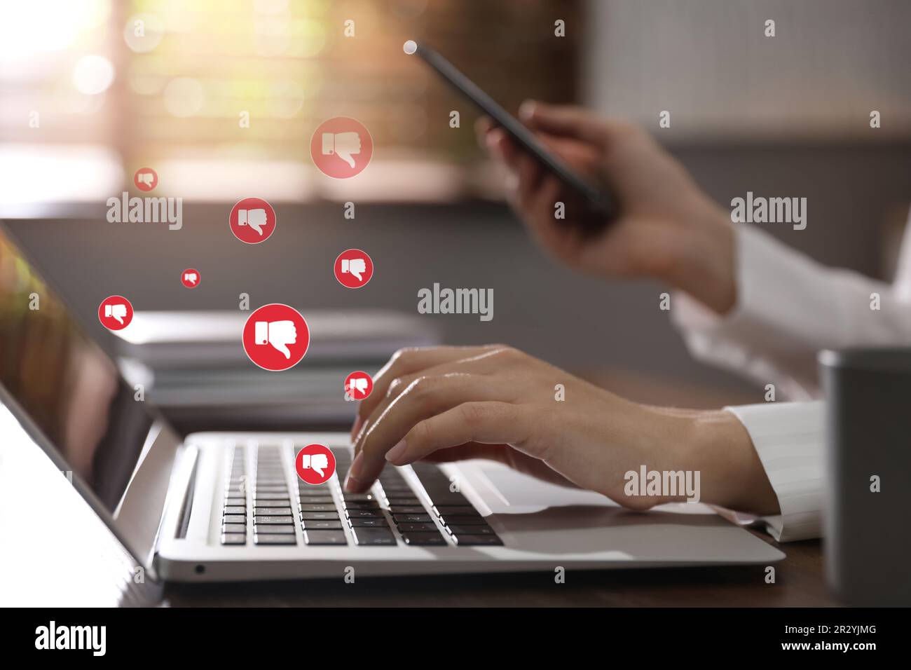 Social media dislike reaction. Woman using laptop and mobile phone at ...