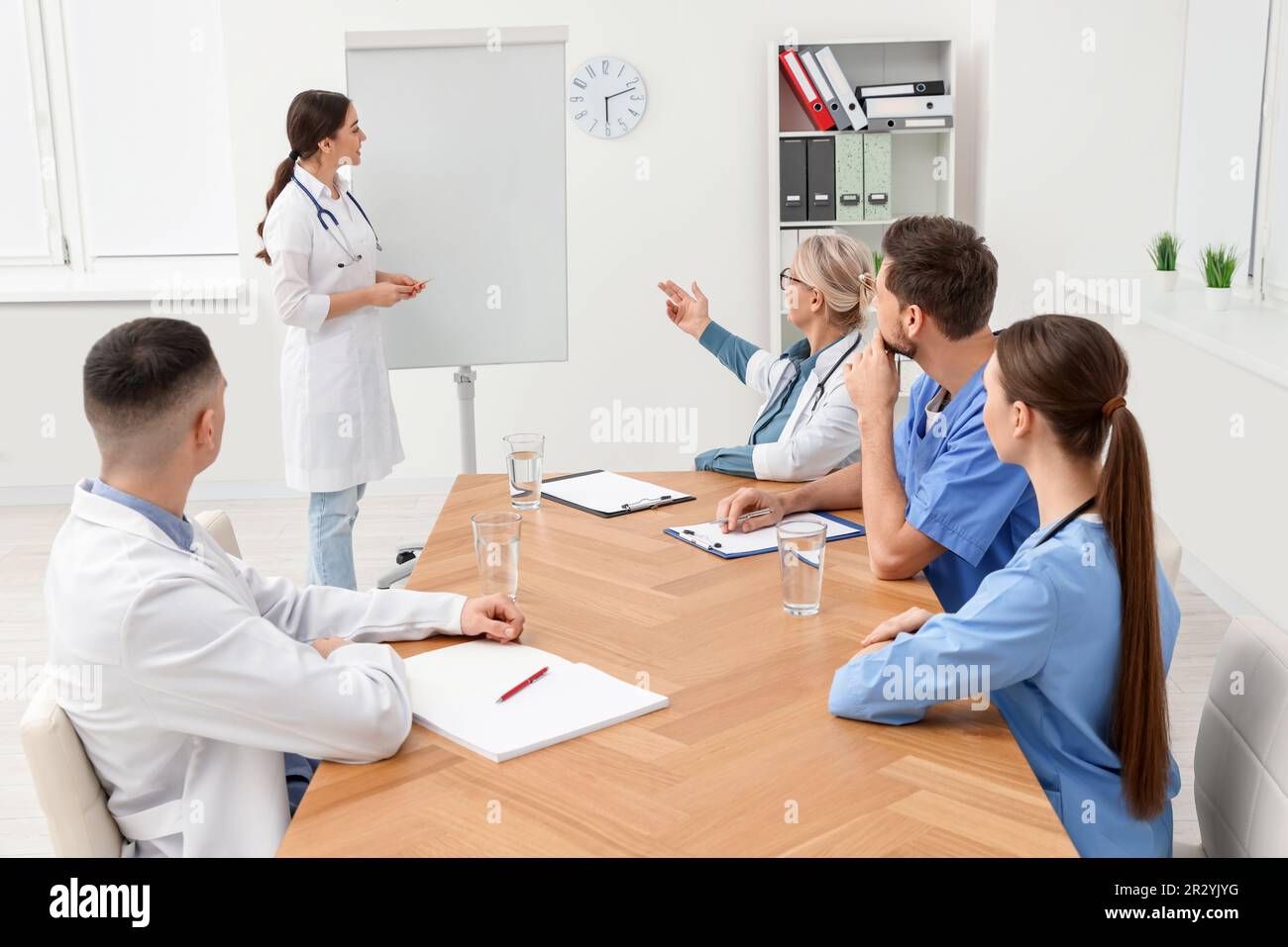 Doctor giving lecture near flipchart in conference room Stock Photo - Alamy