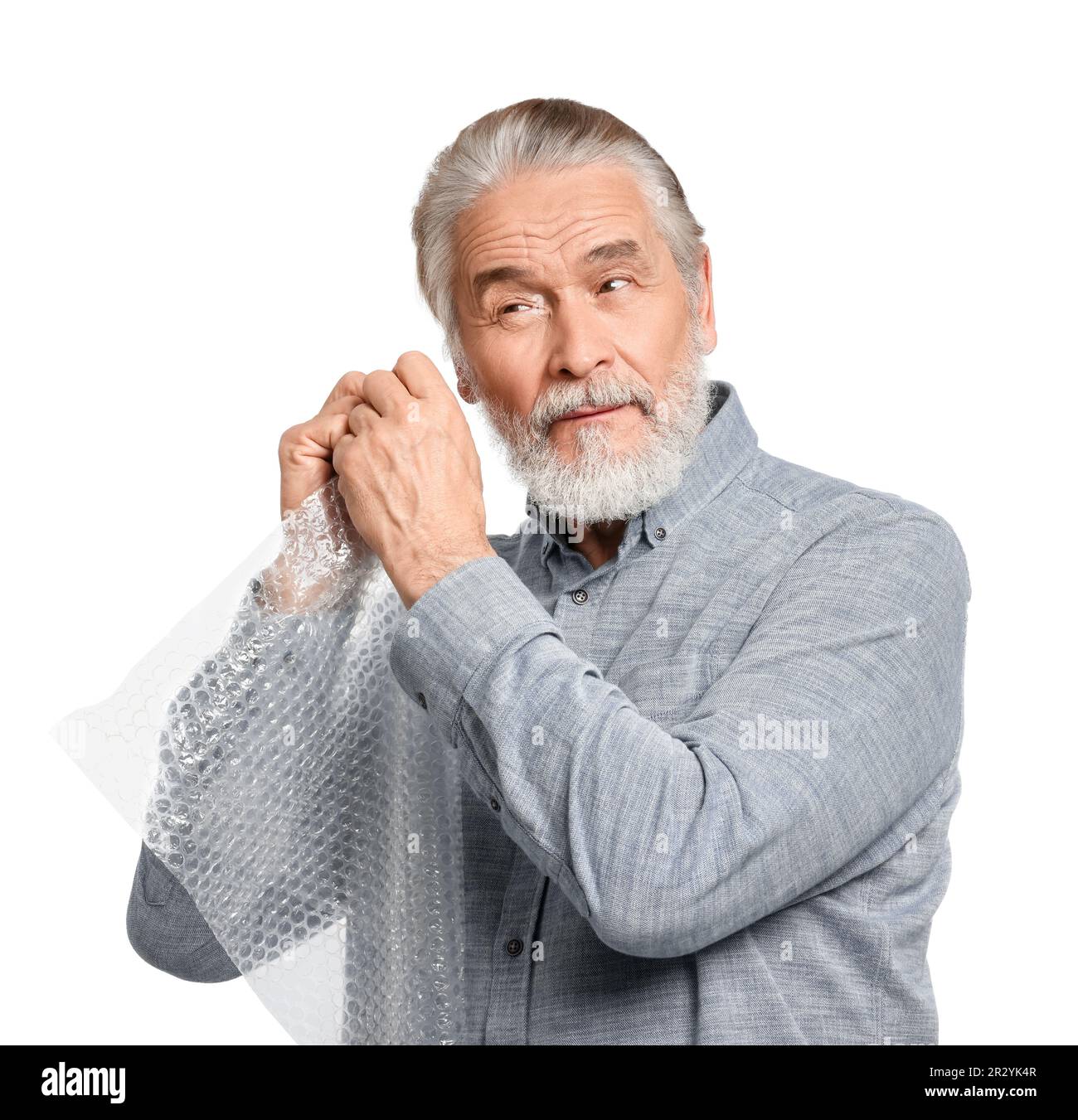 Senior man popping bubble wrap on white background. Stress relief Stock ...