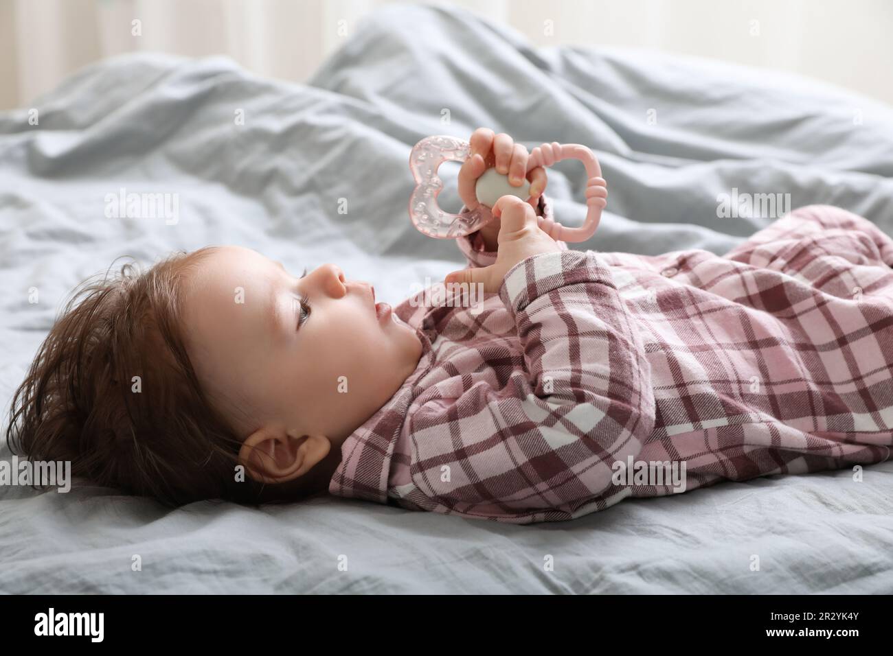Cute little baby with toy on bed Stock Photo - Alamy