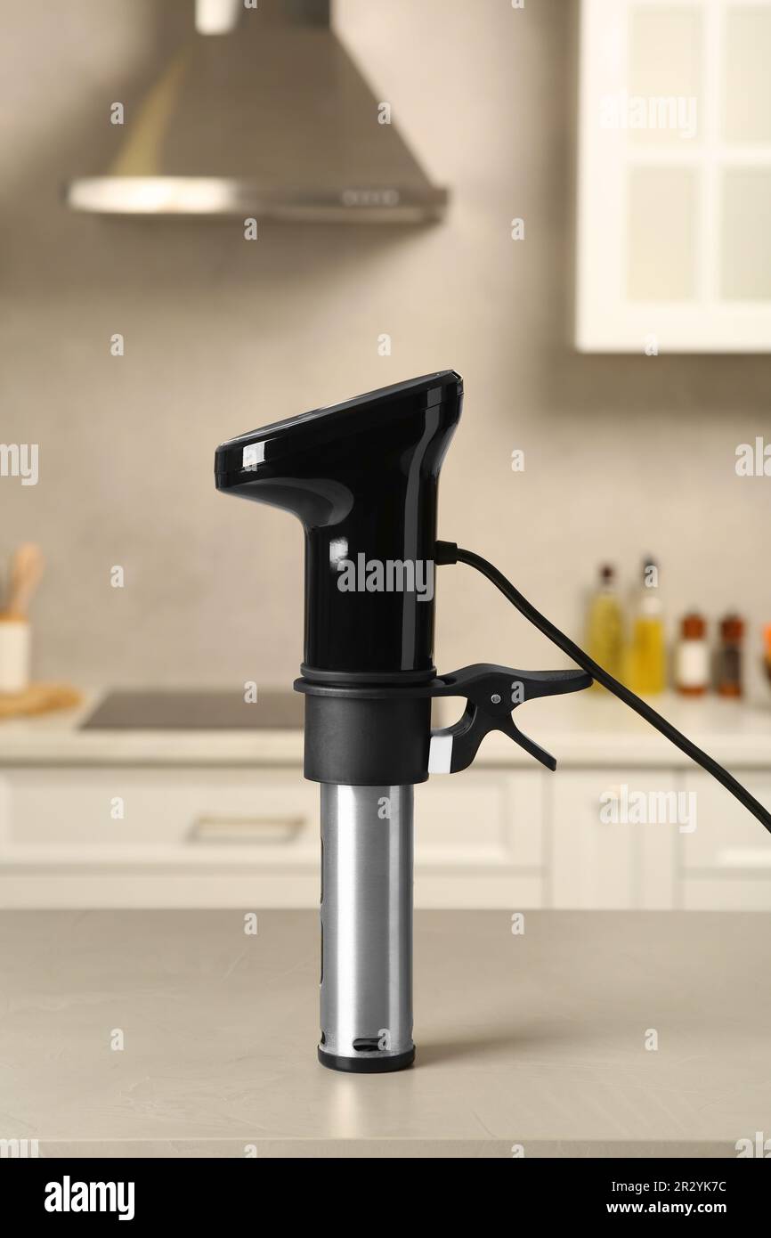 Thermal immersion circulator on white table in kitchen. Sous vide ...