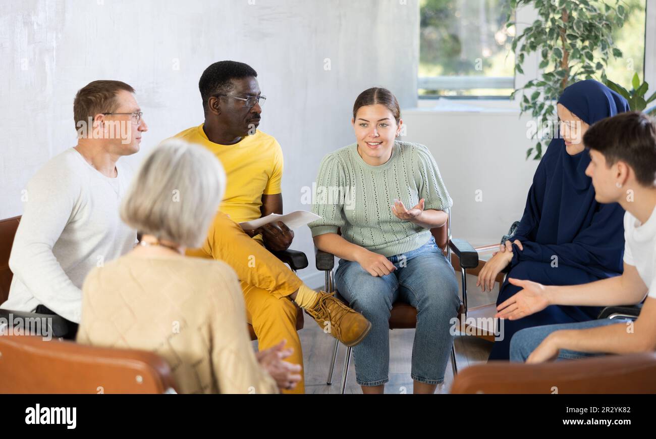 Woman tells an interesting story. Multinational students listening ...