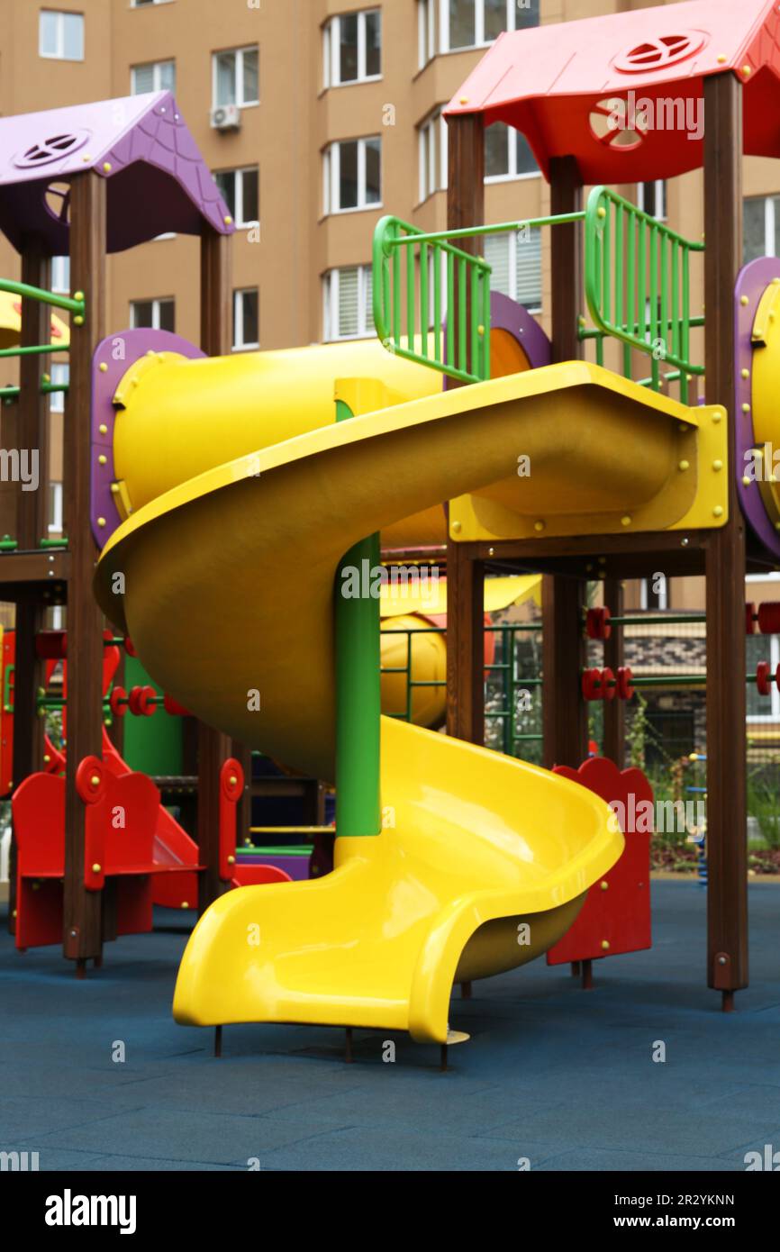 Colourful slide on outdoor playground for children in residential area ...