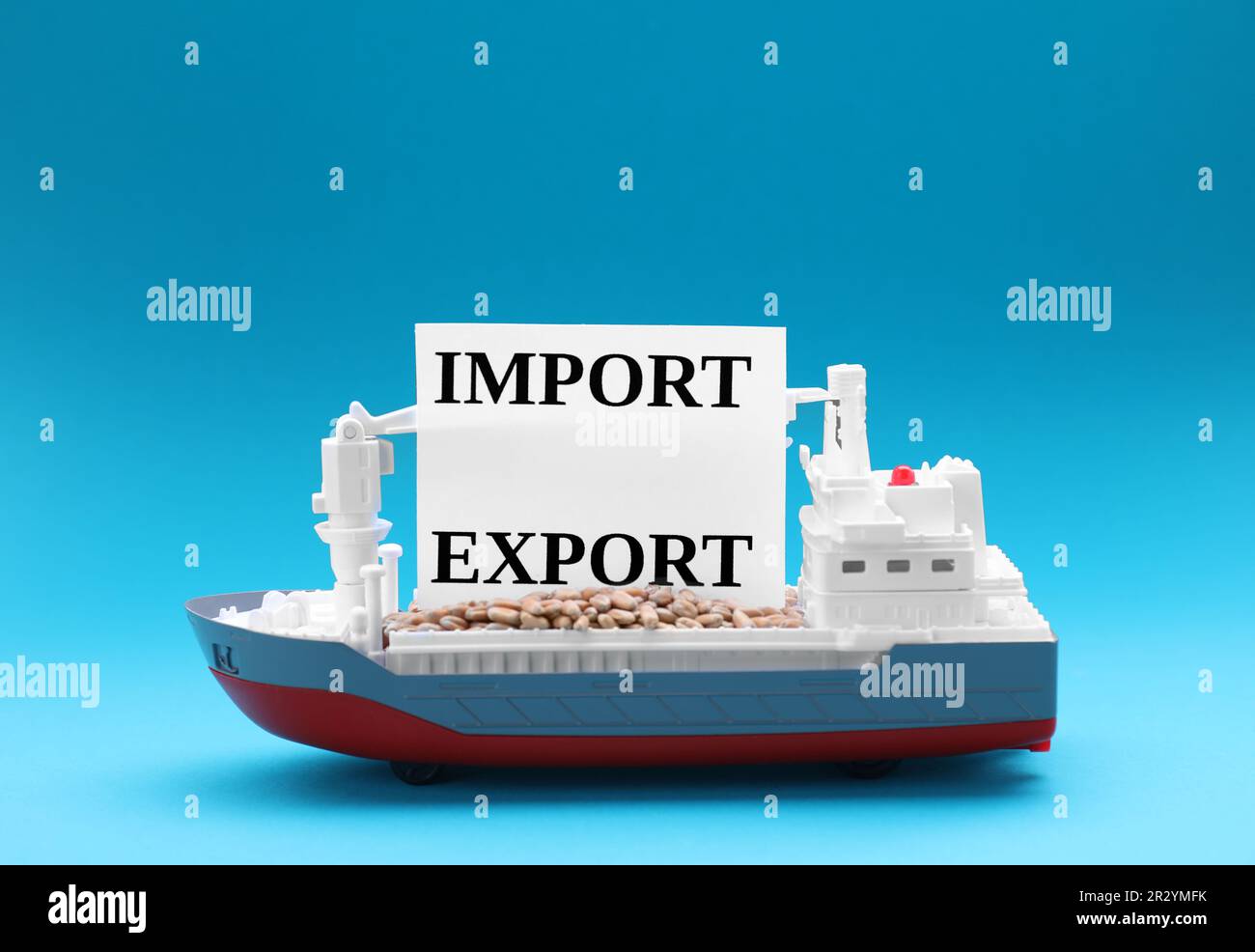 Toy cargo vessel with words Import and Export on light blue background ...