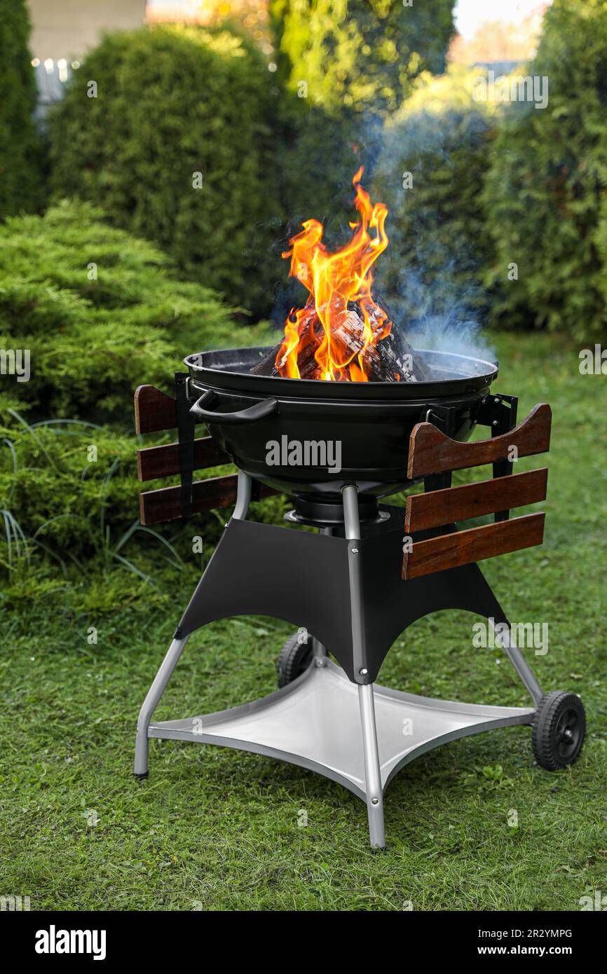 Portable barbecue grill with fire flames outdoors Stock Photo - Alamy
