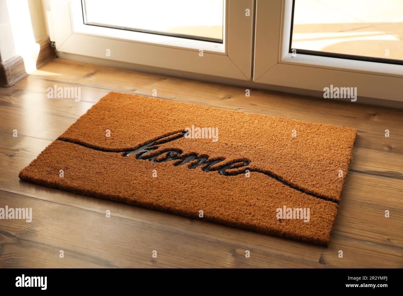 Doormat with word Home on parquet floor indoors Stock Photo - Alamy