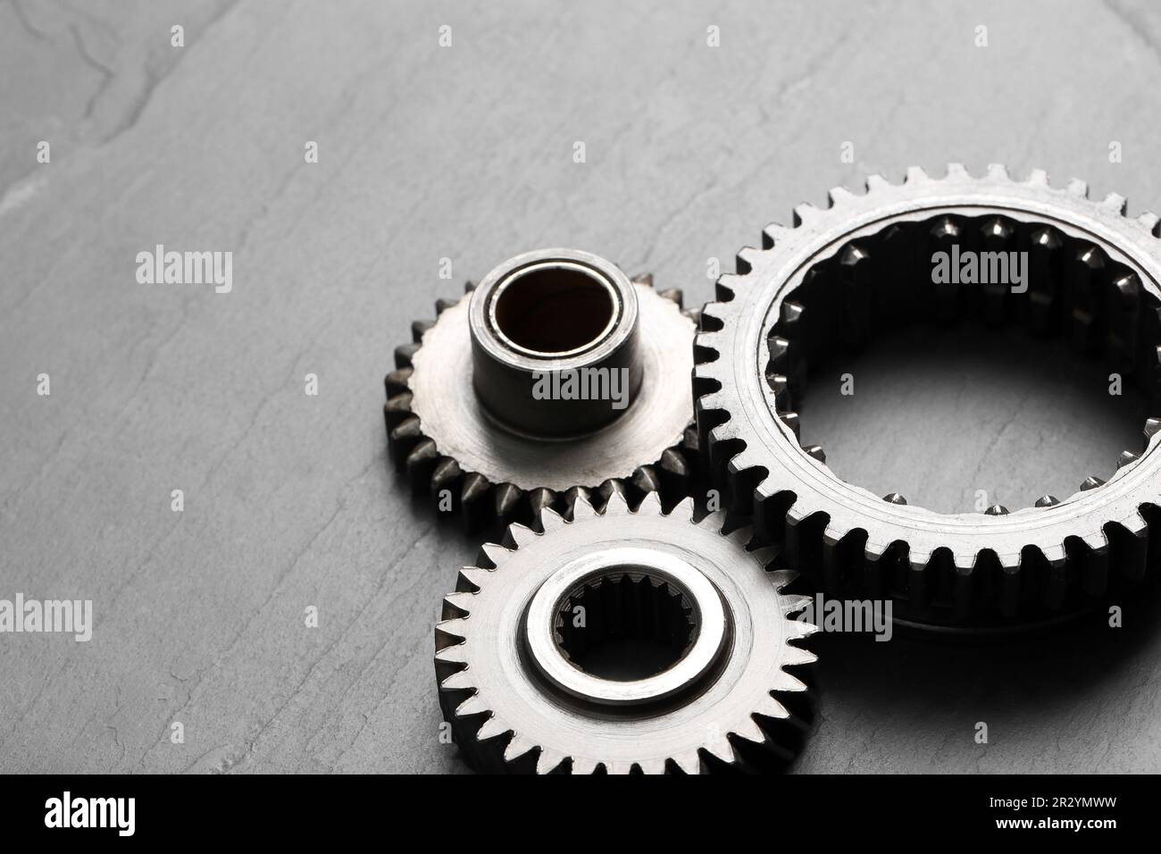 Different stainless steel gears on grey background, space for text ...