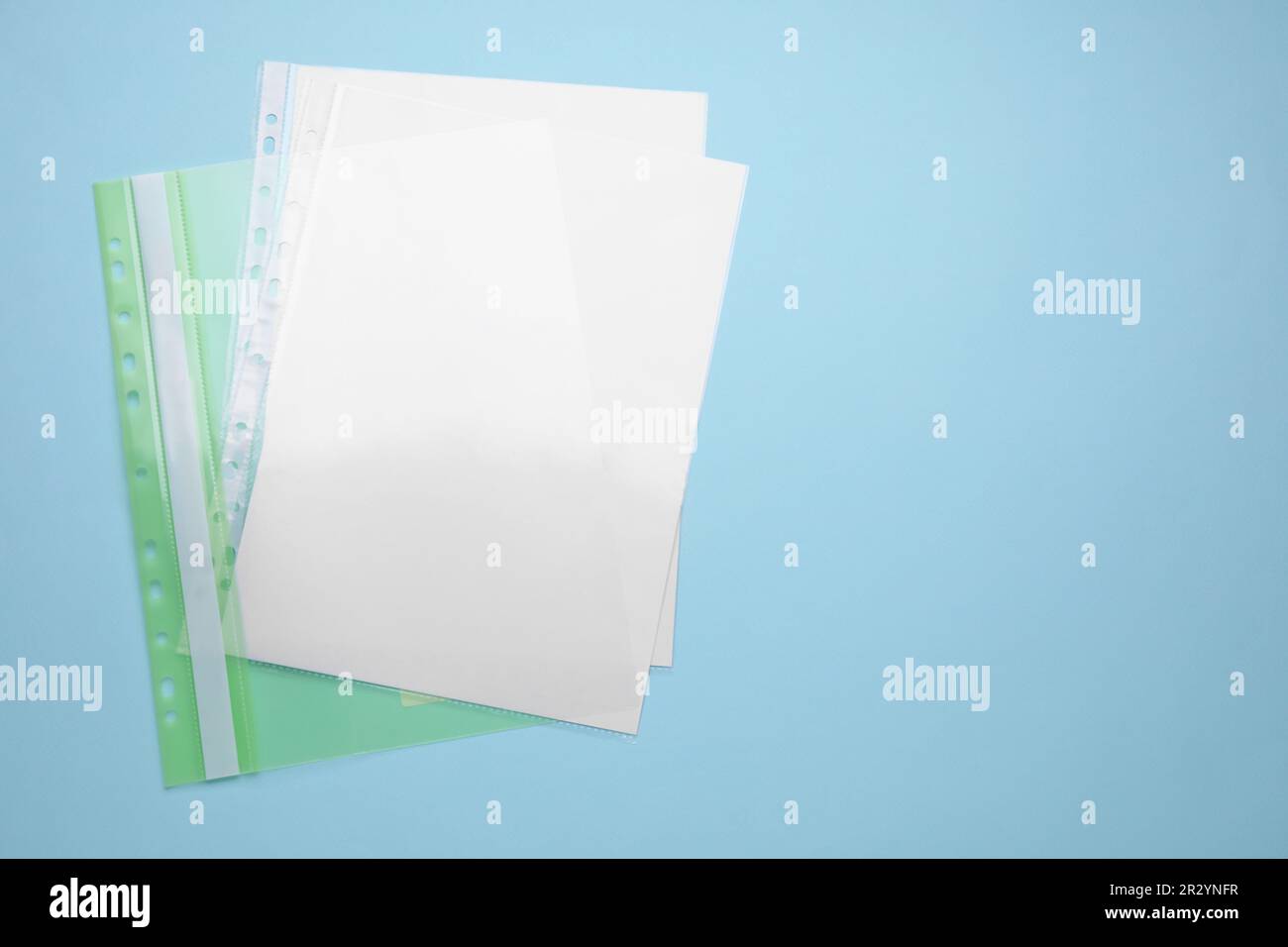 File folder with punched pockets and paper sheets on turquoise ...