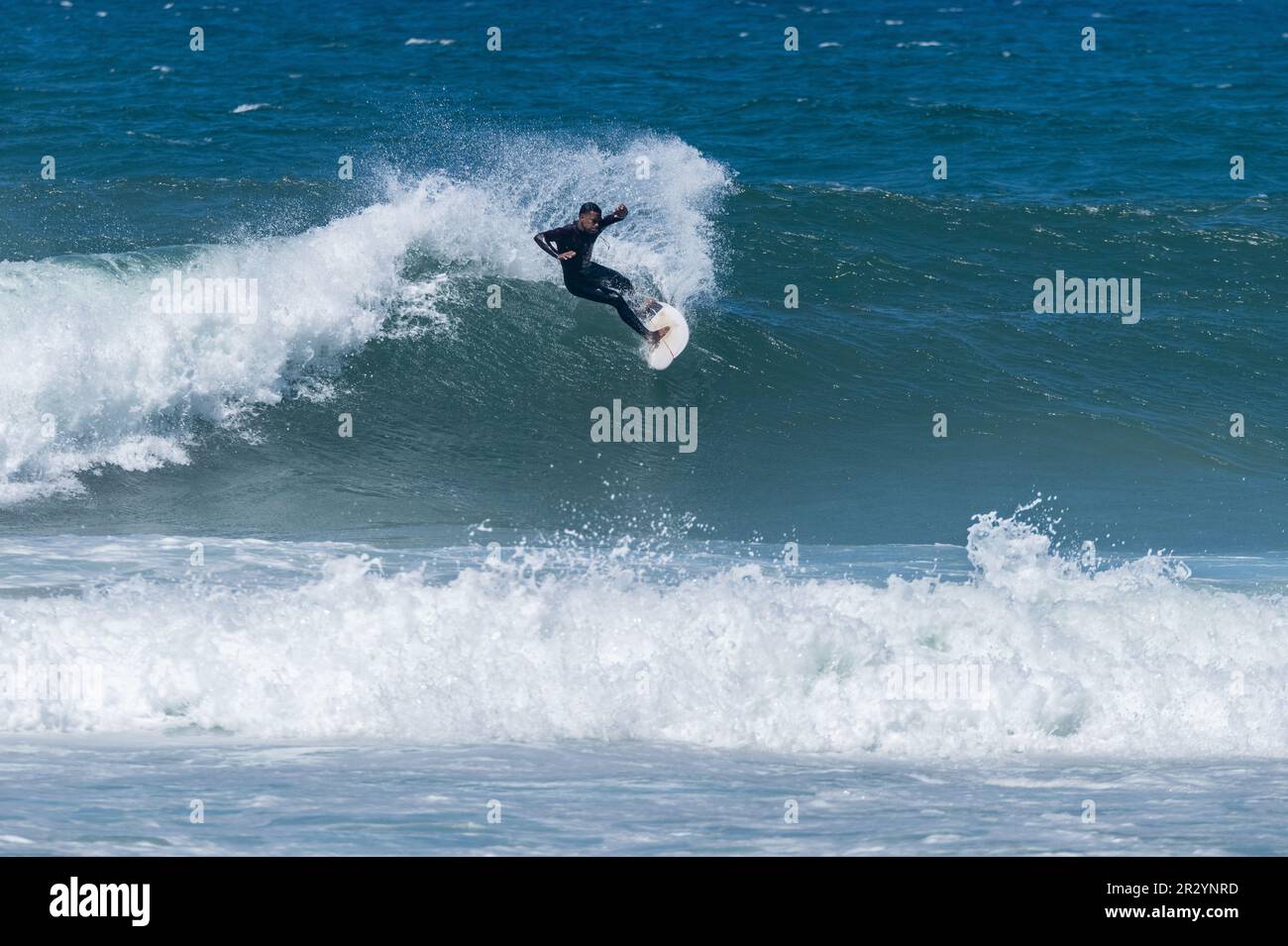 Surfer riding waves in Furadouro Beach, Portugal. Men catching waves in ...