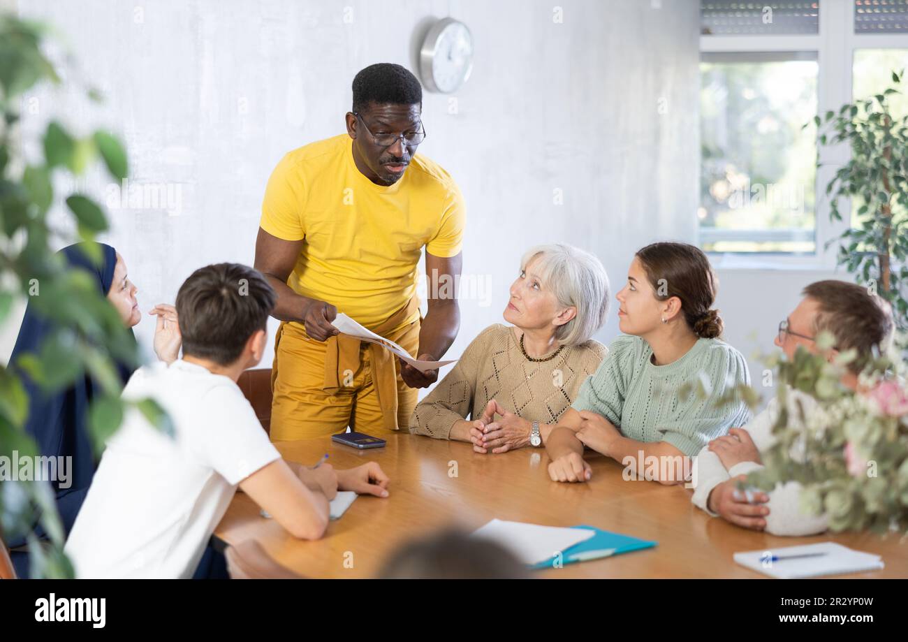 Experienced male coach conducts training for people of different ...