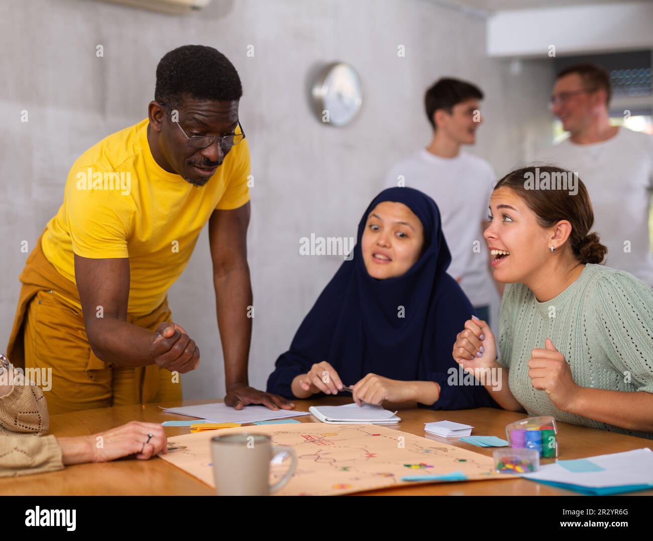 Group of multinational students of different years play board game with ...