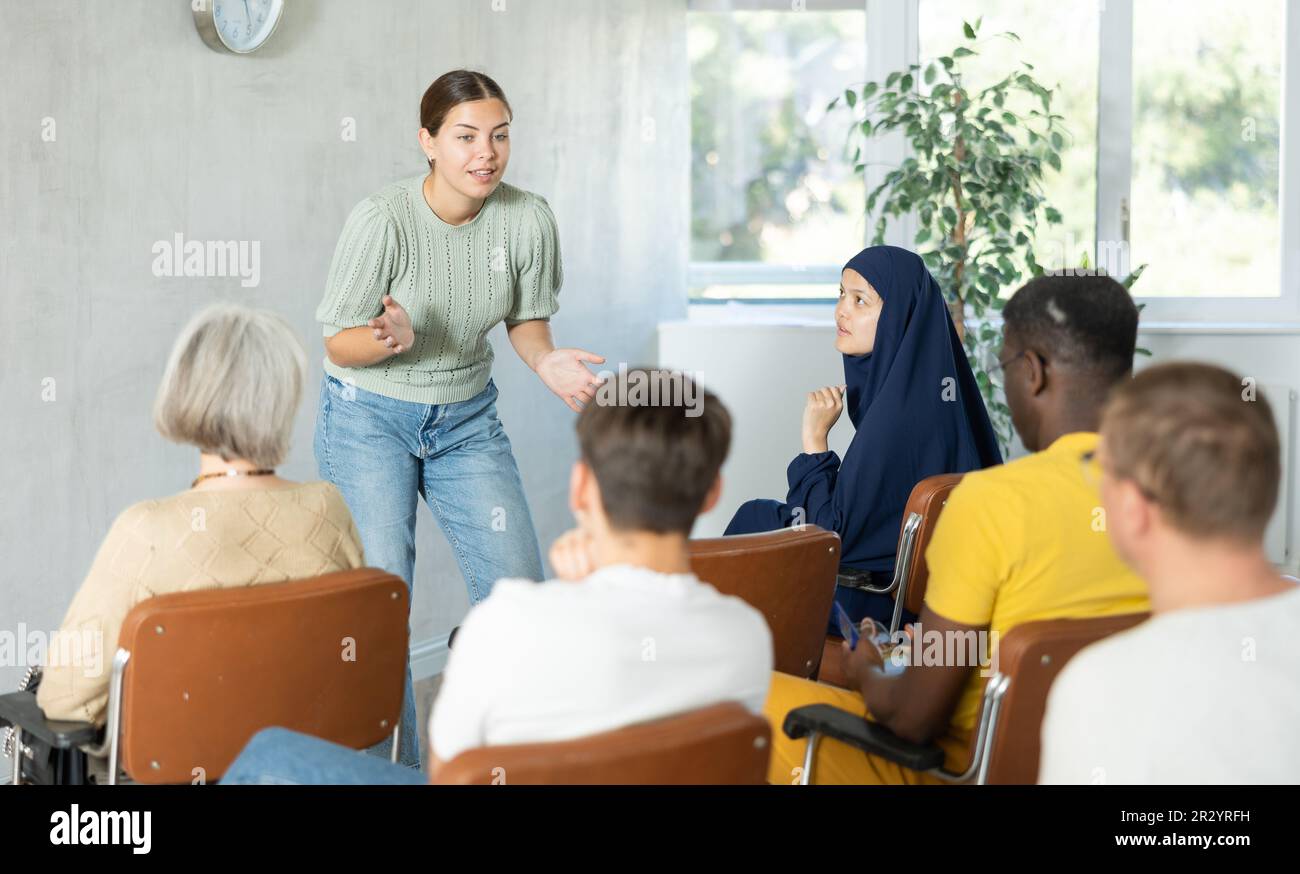 Young female tutor leading educational class for multiethnic group ...
