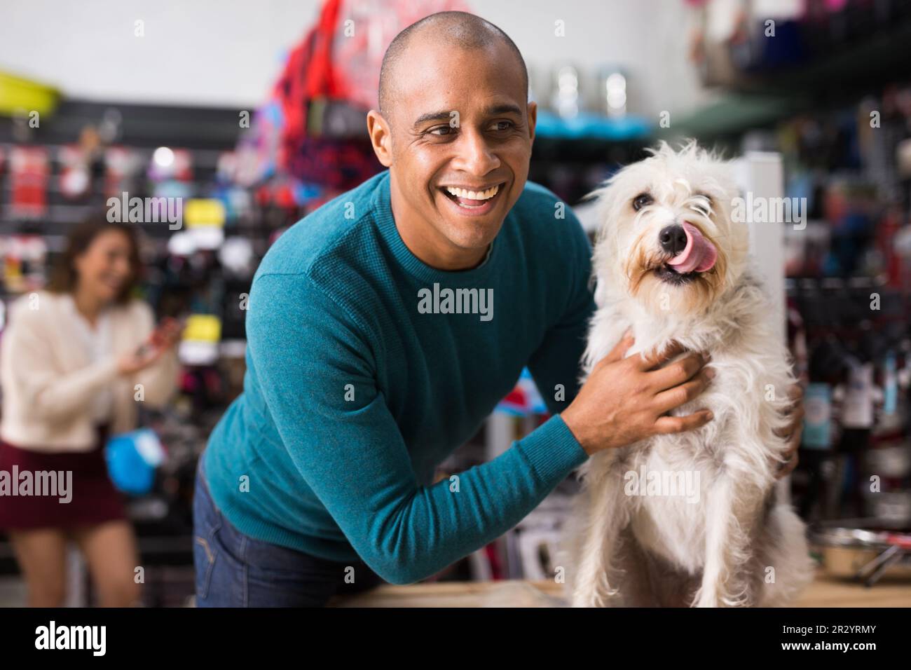 Emotional man hugging dog in pet store Stock Photo - Alamy