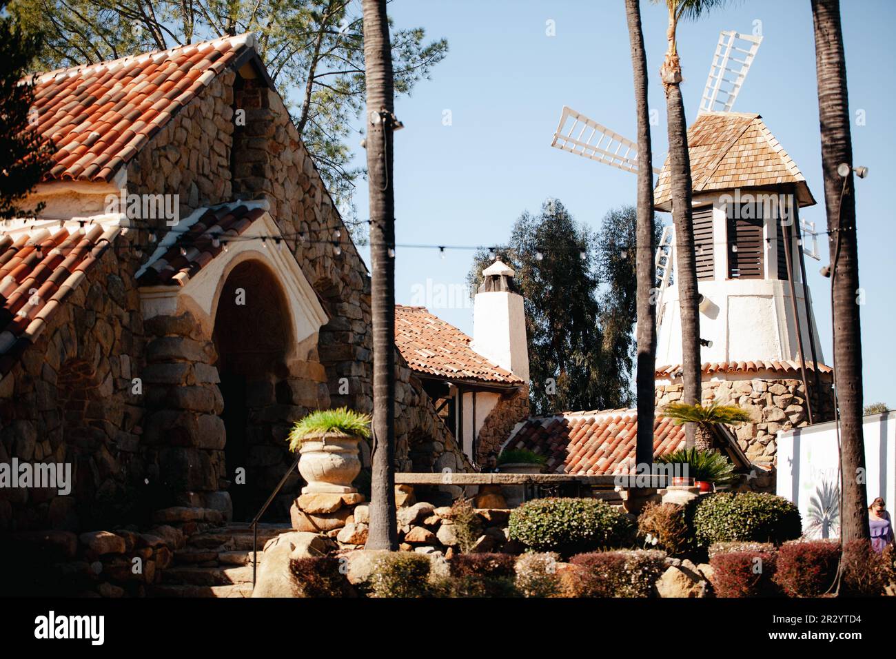 Windmill with old rock castle. red tile roof and string lights. Modern ...
