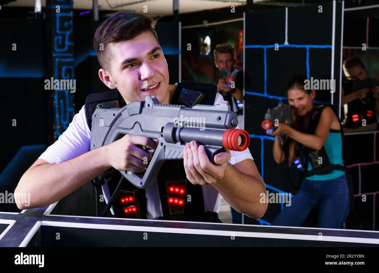 Excited guy holding laser pistol during playing laser tag with his ...