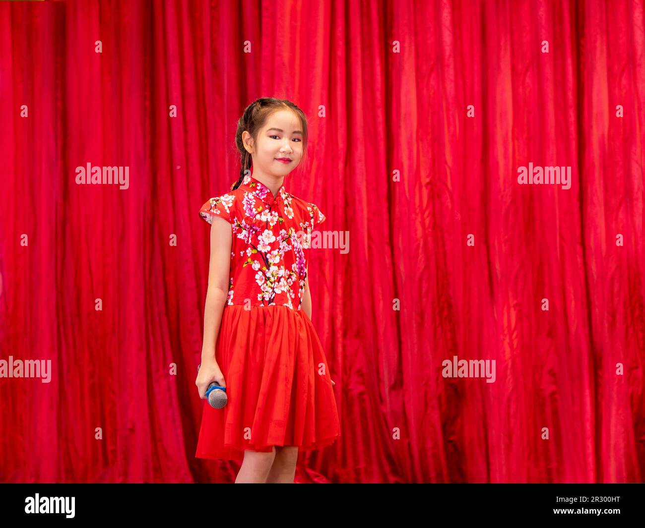 The Asian kid girl sing a song on stage at her school activity day ...
