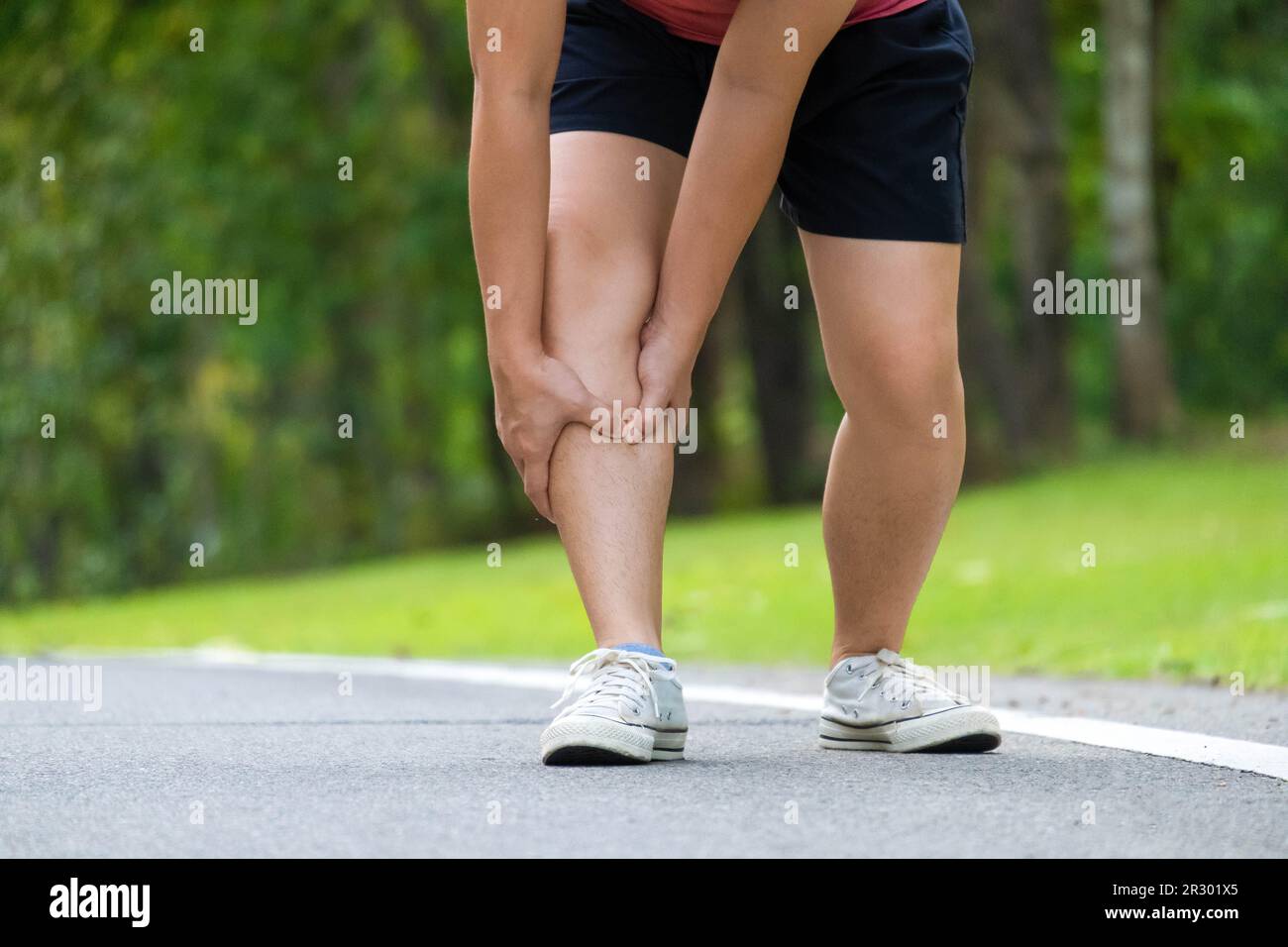 Close-up of young female athlete having knee pain after exercise ...