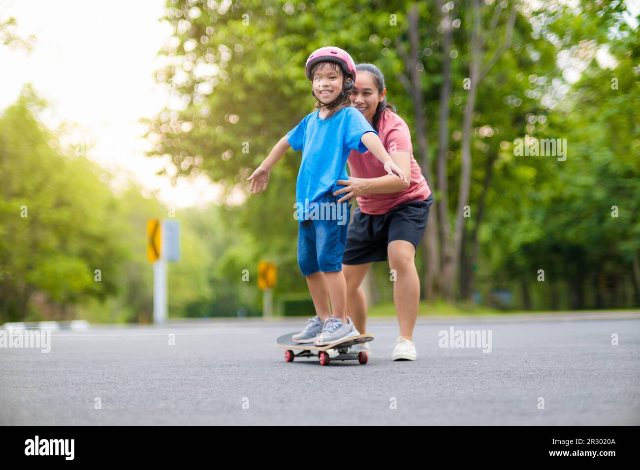 Active little girl and mom enjoy skateboarding. Cute little girl ...