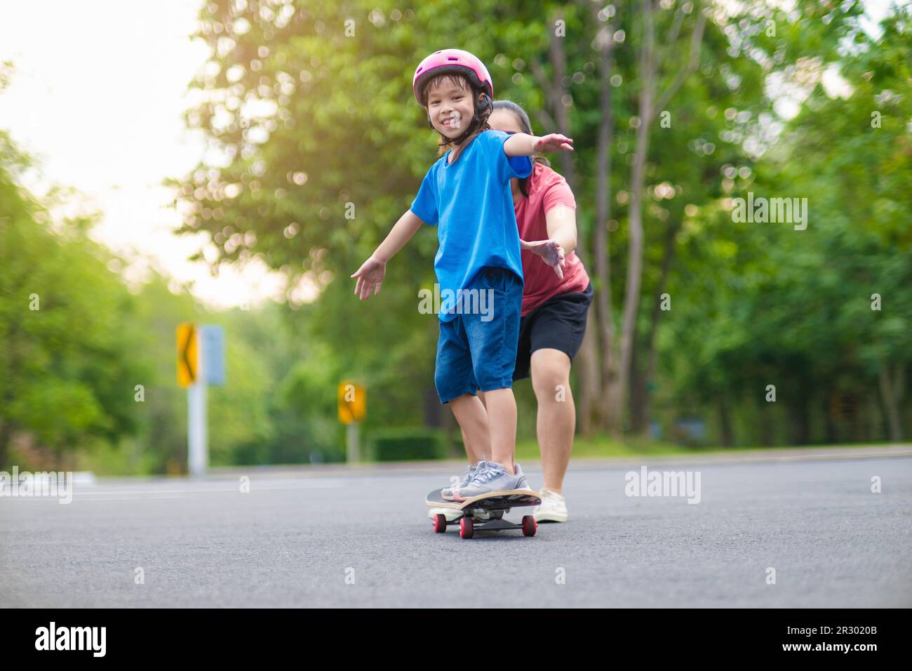 Active little girl and mom enjoy skateboarding. Cute little girl ...