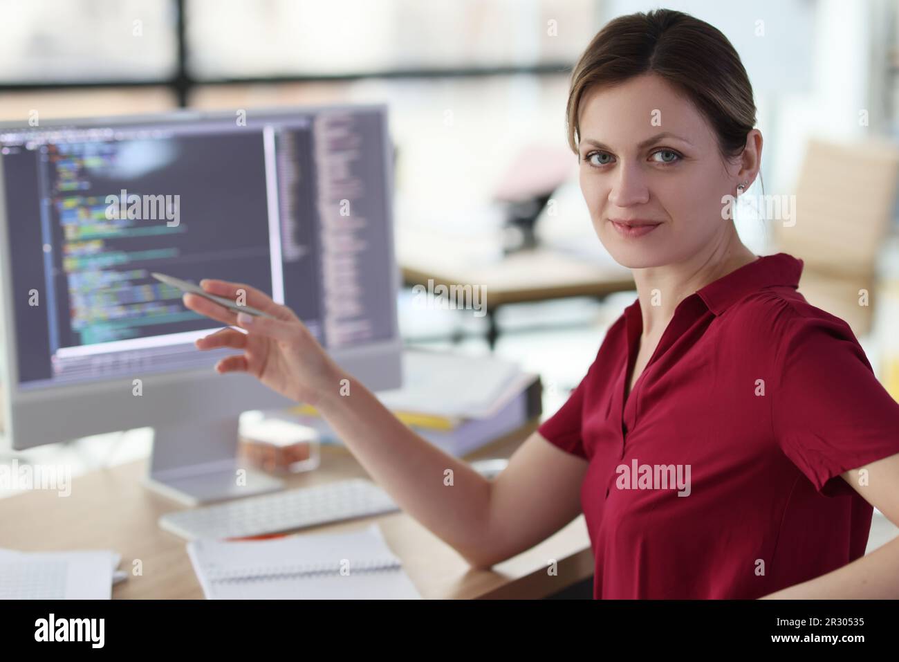 Woman shows with pen on complex code developing software Stock Photo - Alamy