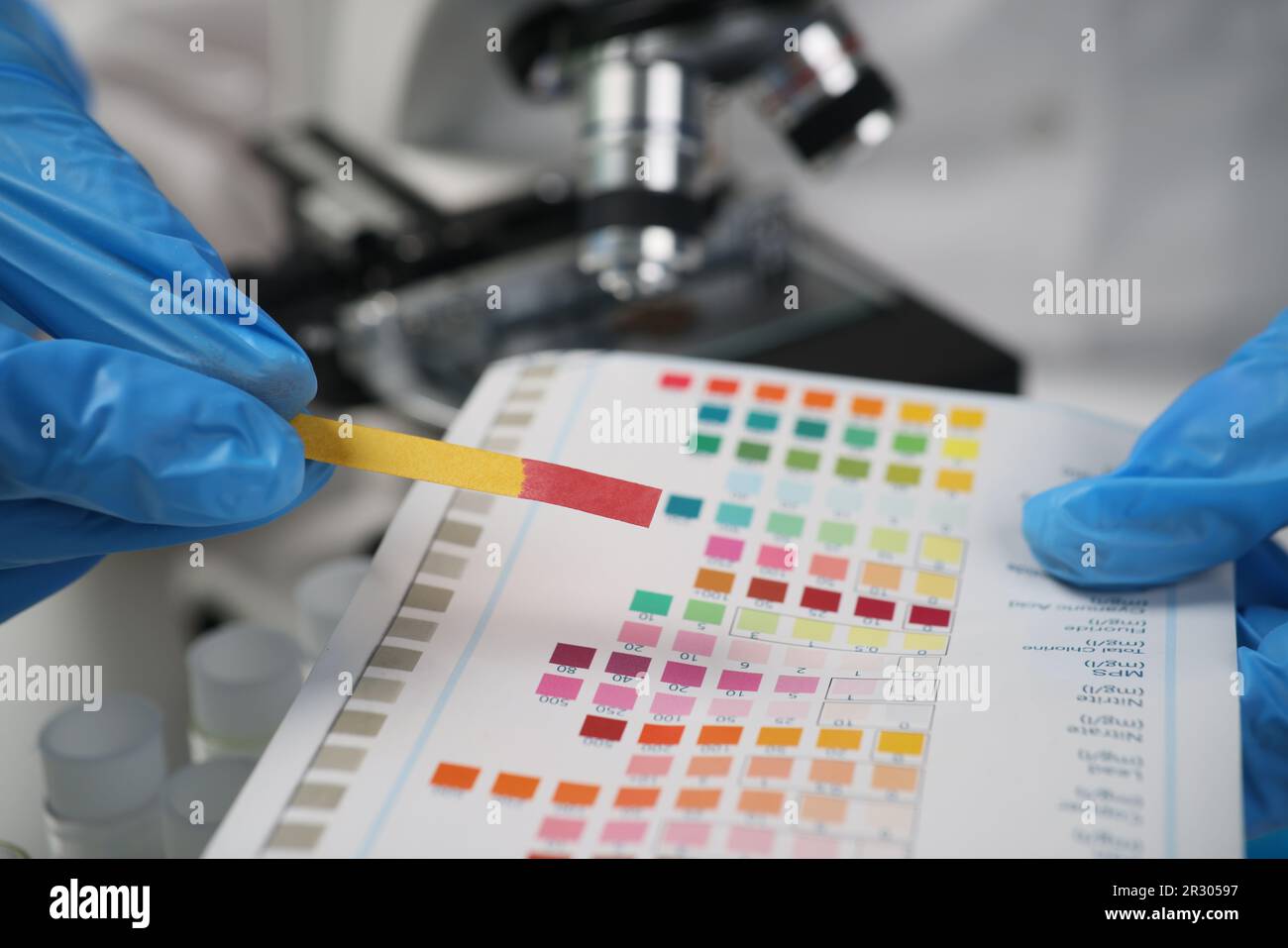 Laboratory worker compares color of stick with indicators Stock Photo ...