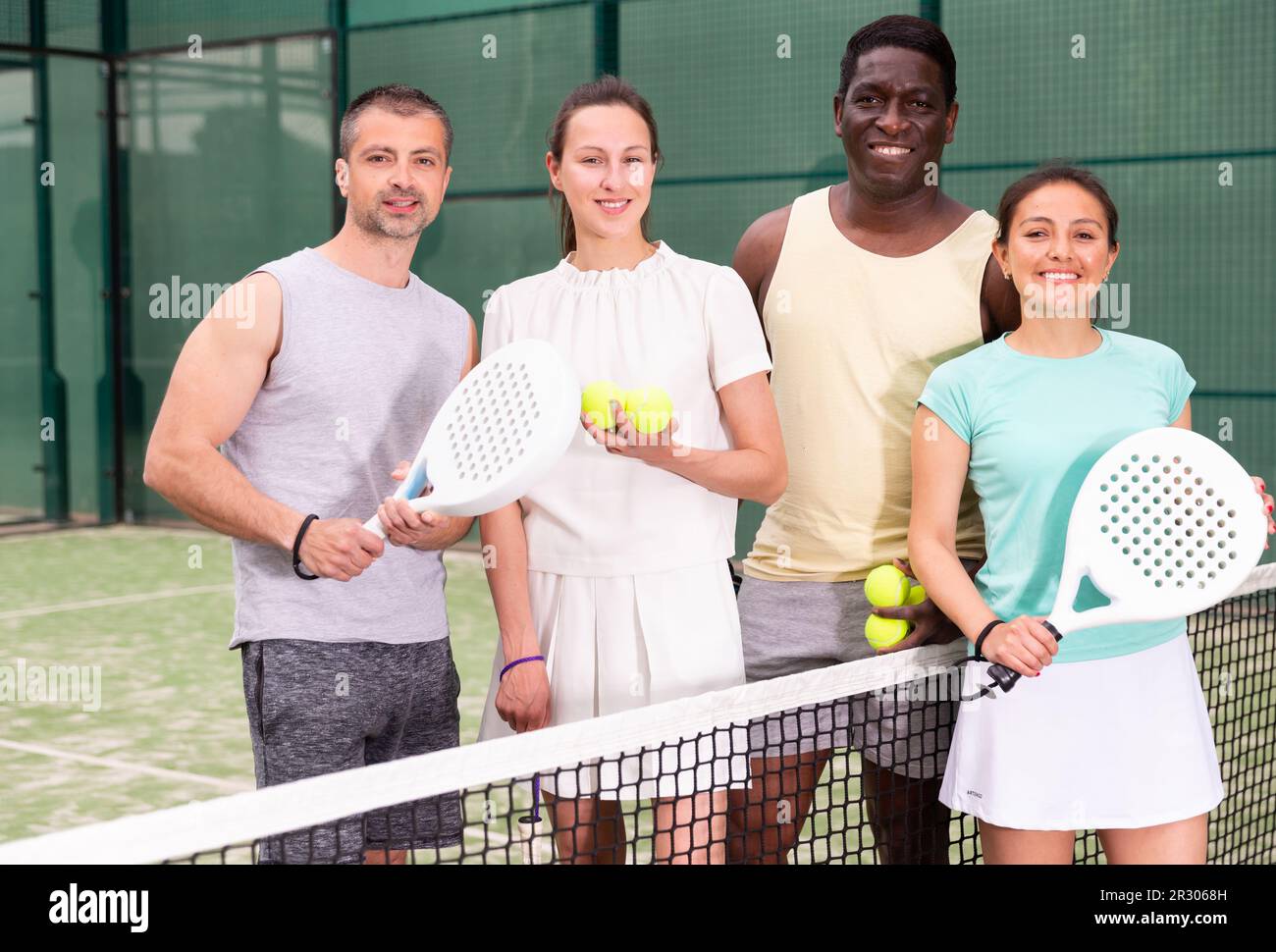Two happy couples after playing padel on tennis court Stock Photo - Alamy