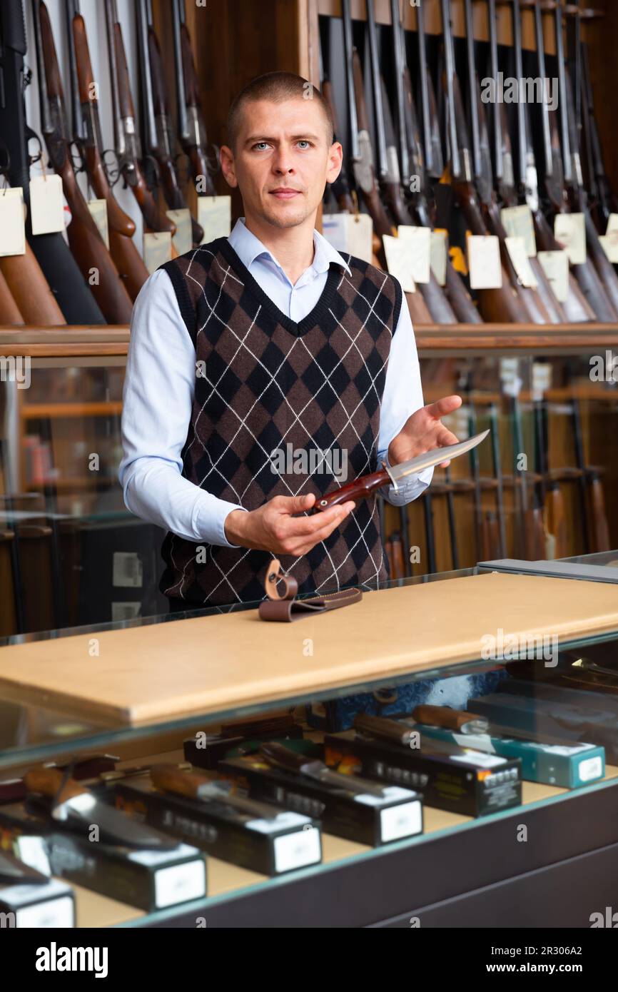 Gun shop owner showing hunting dagger with double edged blade Stock ...