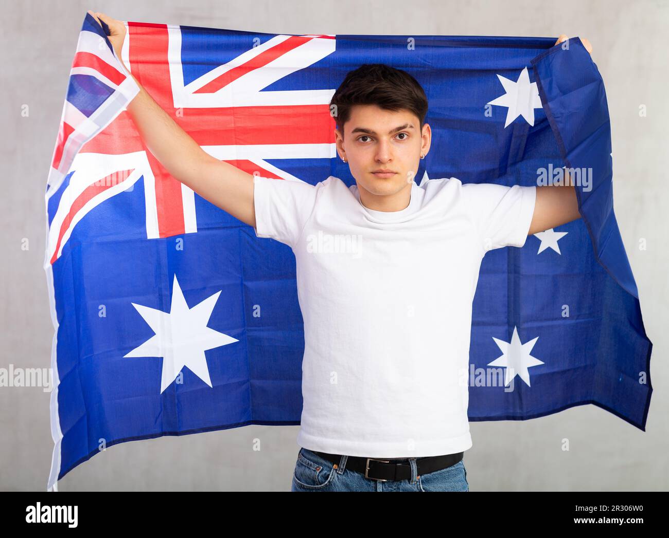 Focused young guy holding flag of Australia Stock Photo - Alamy