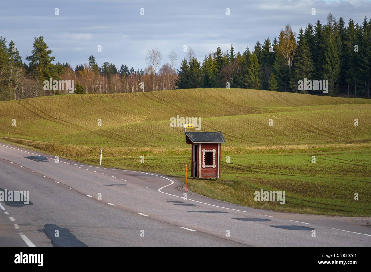 Bus stop in Finnish countryside with red wooden shelter and green ...