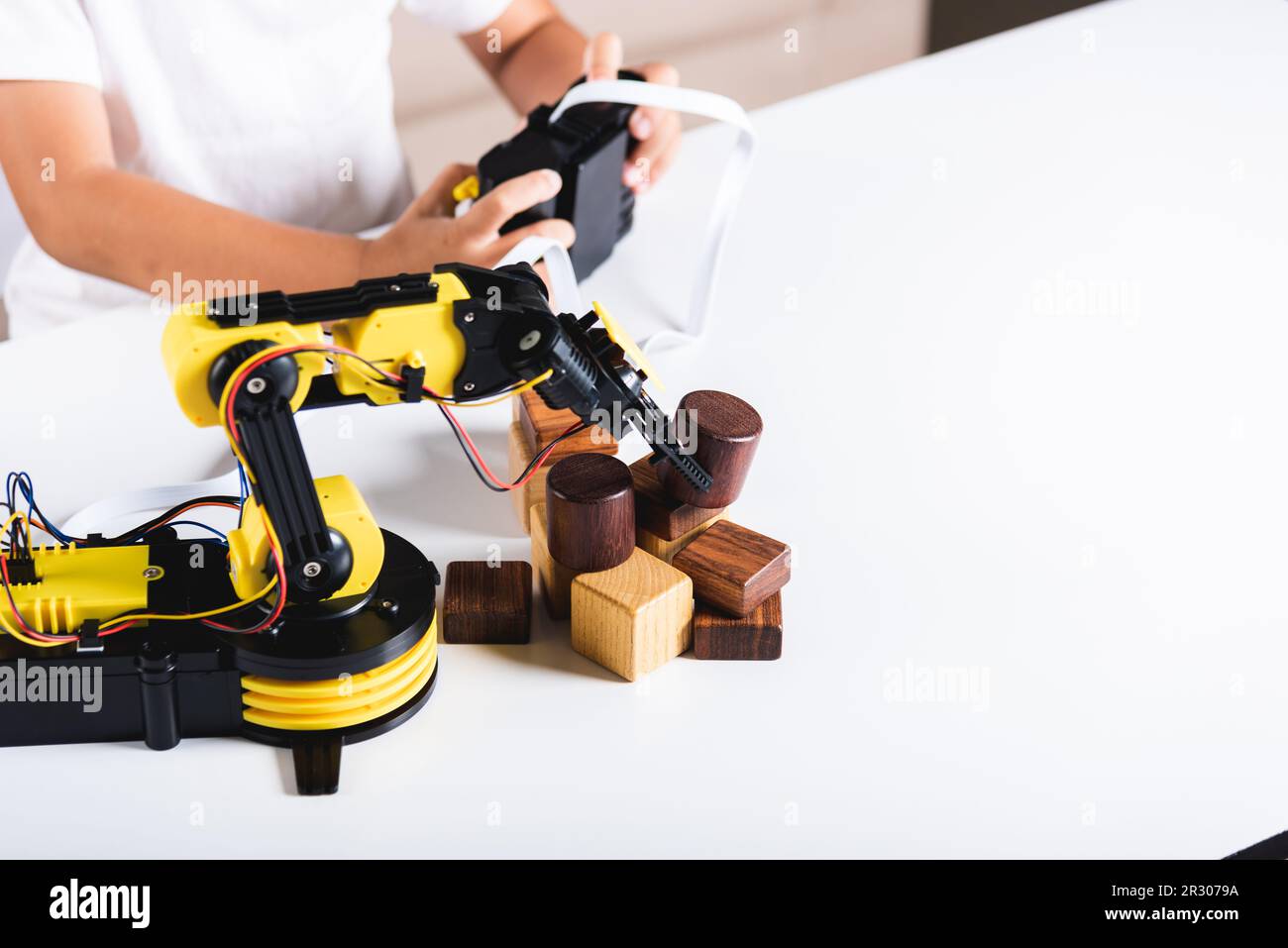 Happy Asian little kid boy using remote control playing robotic machine ...