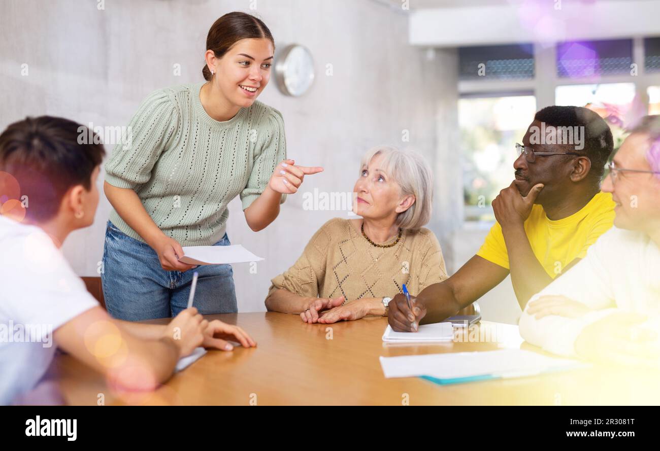 Group of multinational people discussing documents at table Stock Photo ...